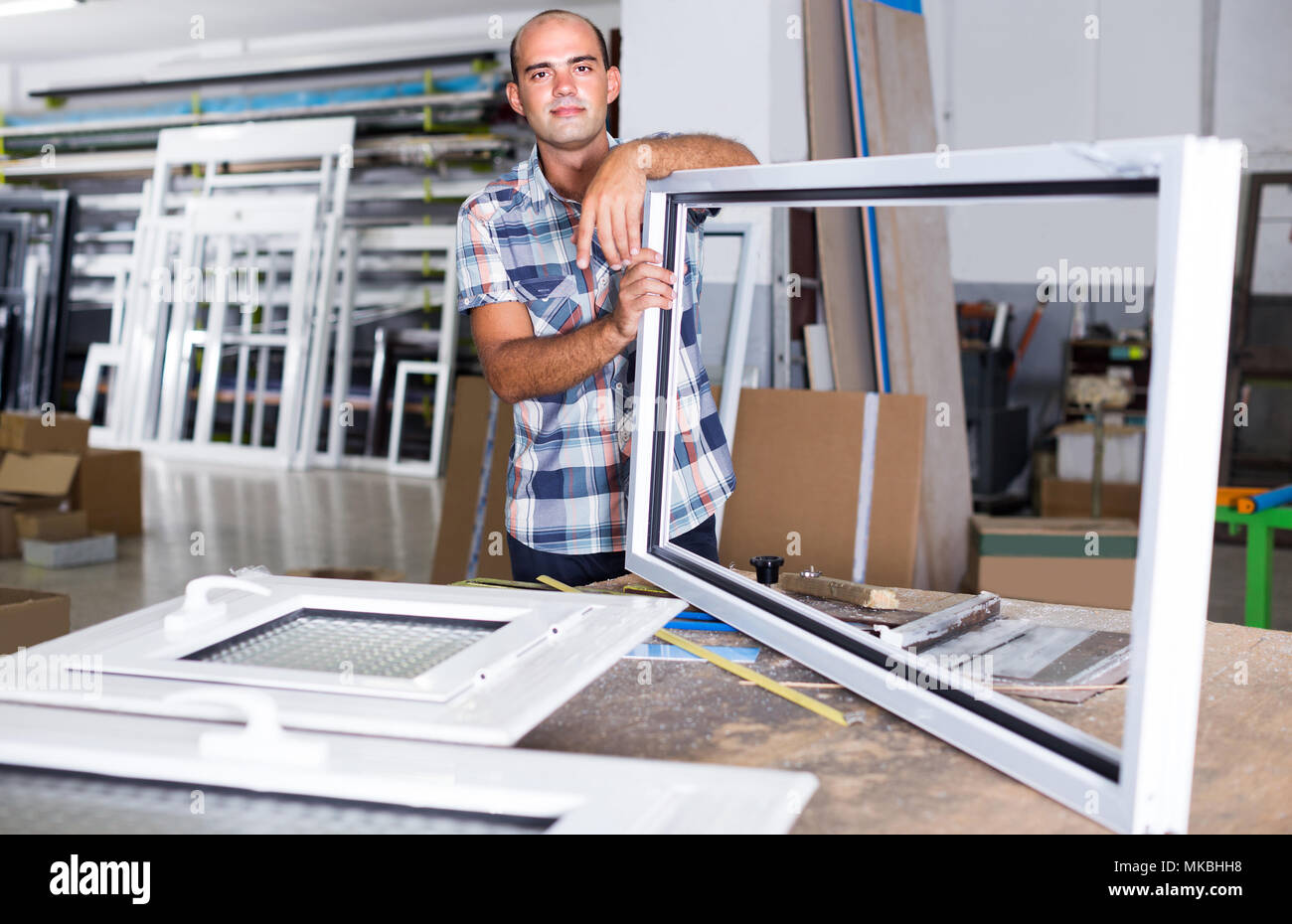 Man 25-30 years old is checking quality of work on assembling plastic ...