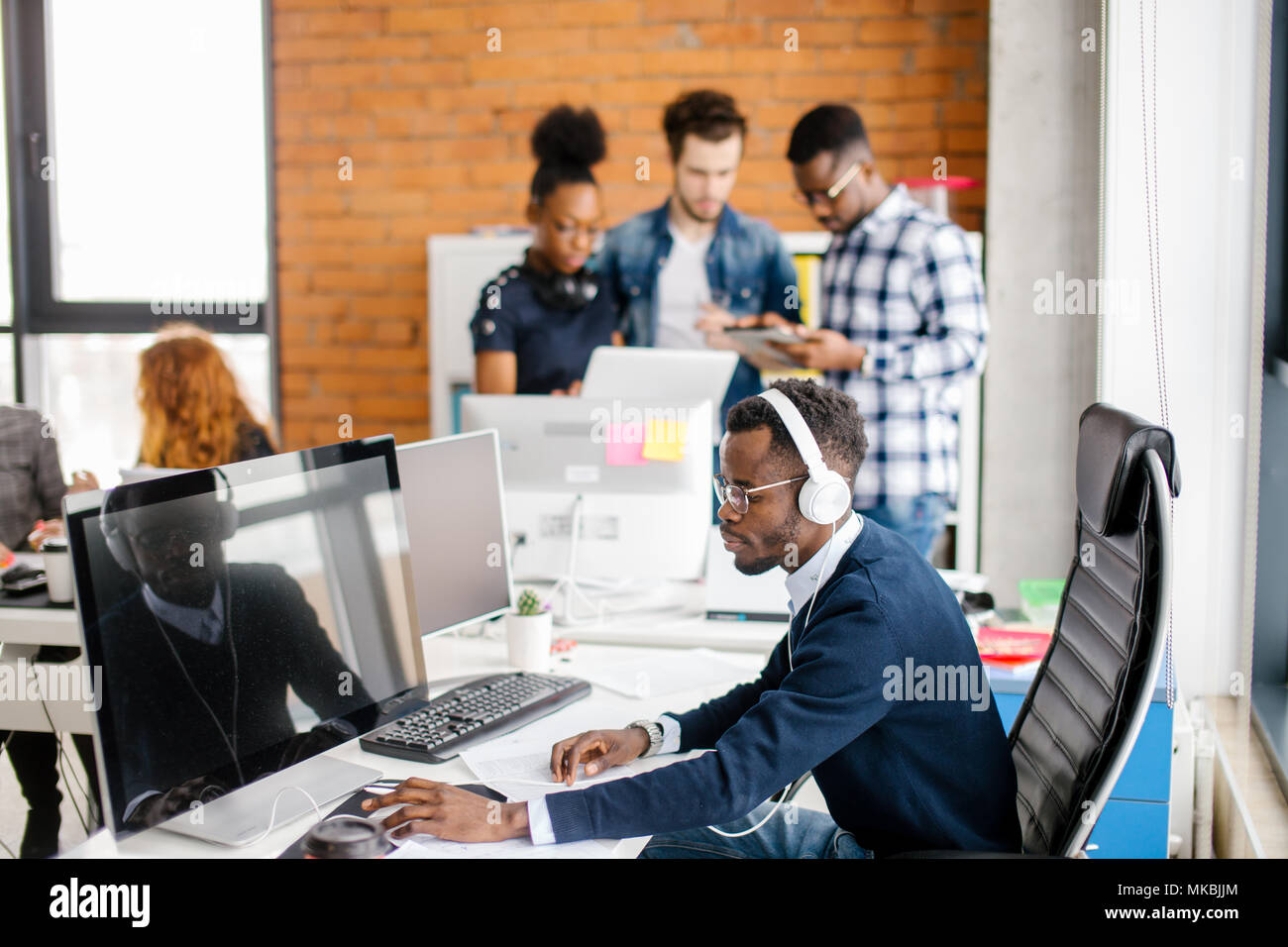 young African programmer working on personal computer in the call ...