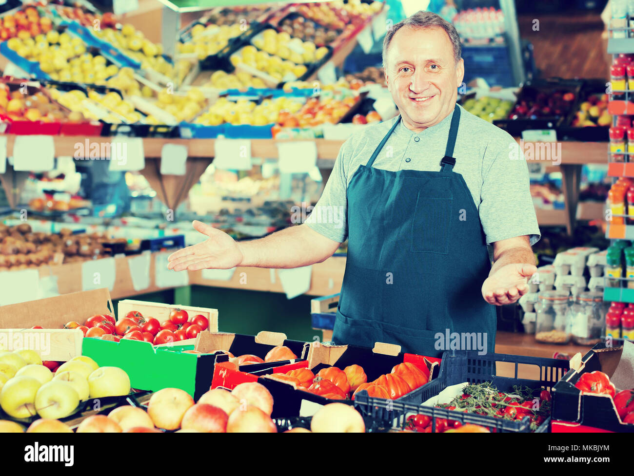 Portrait of adult man seller who is standing on his workplace in ...