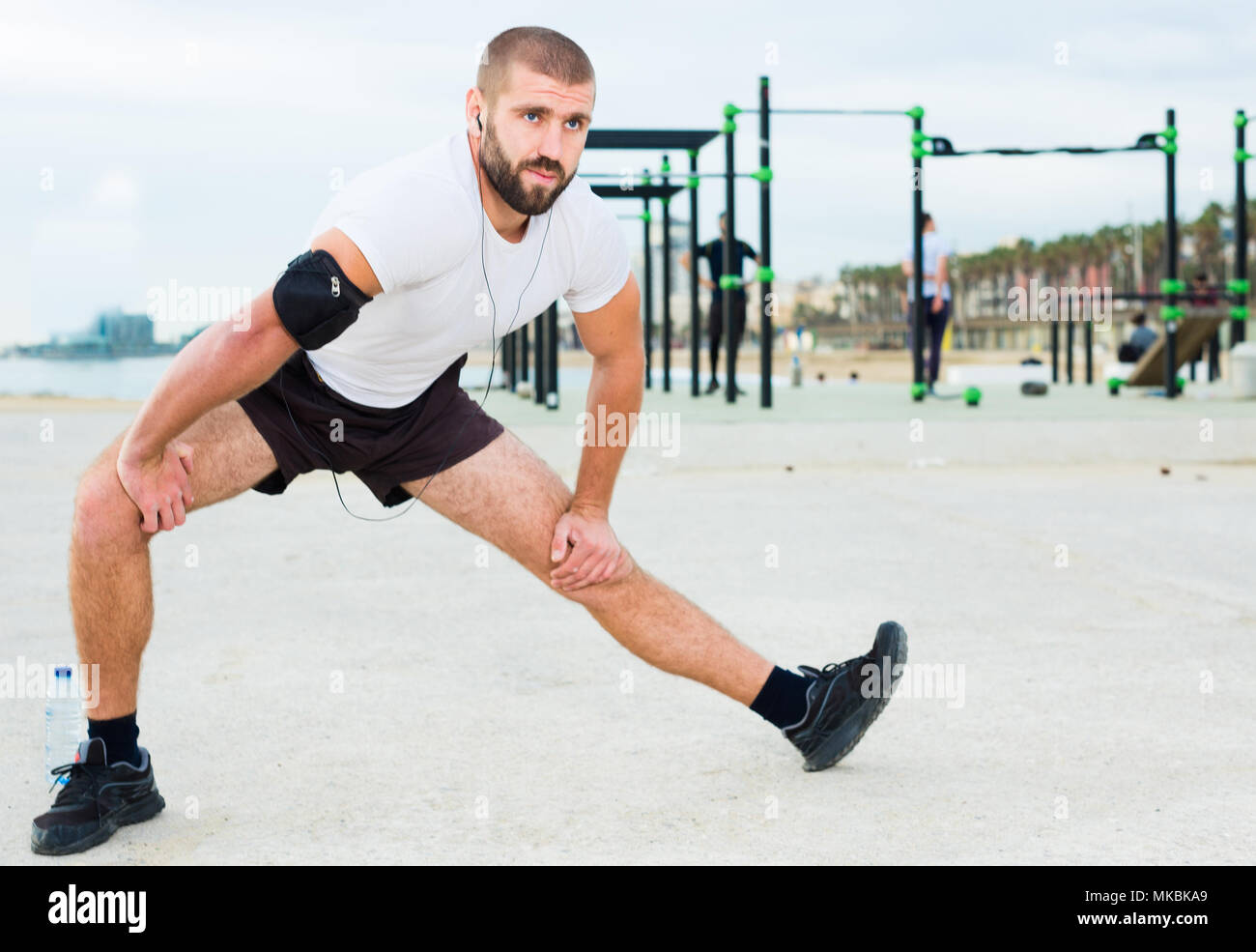 Athletic male performs warm-up exercises before training Stock Photo ...