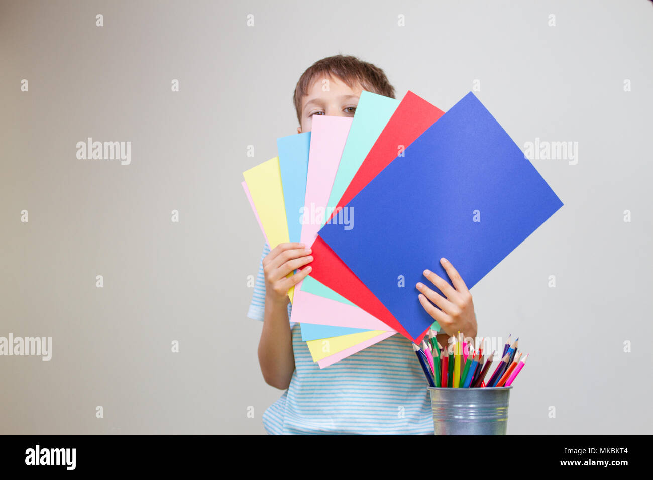 Boy hide his face with the colored paper Stock Photo - Alamy