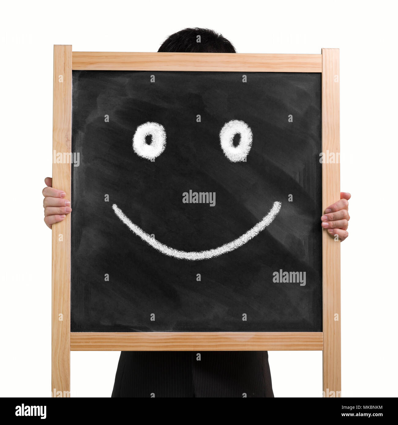 Man's two hands lifting up black wooden chalkboard with drawing smiley ...