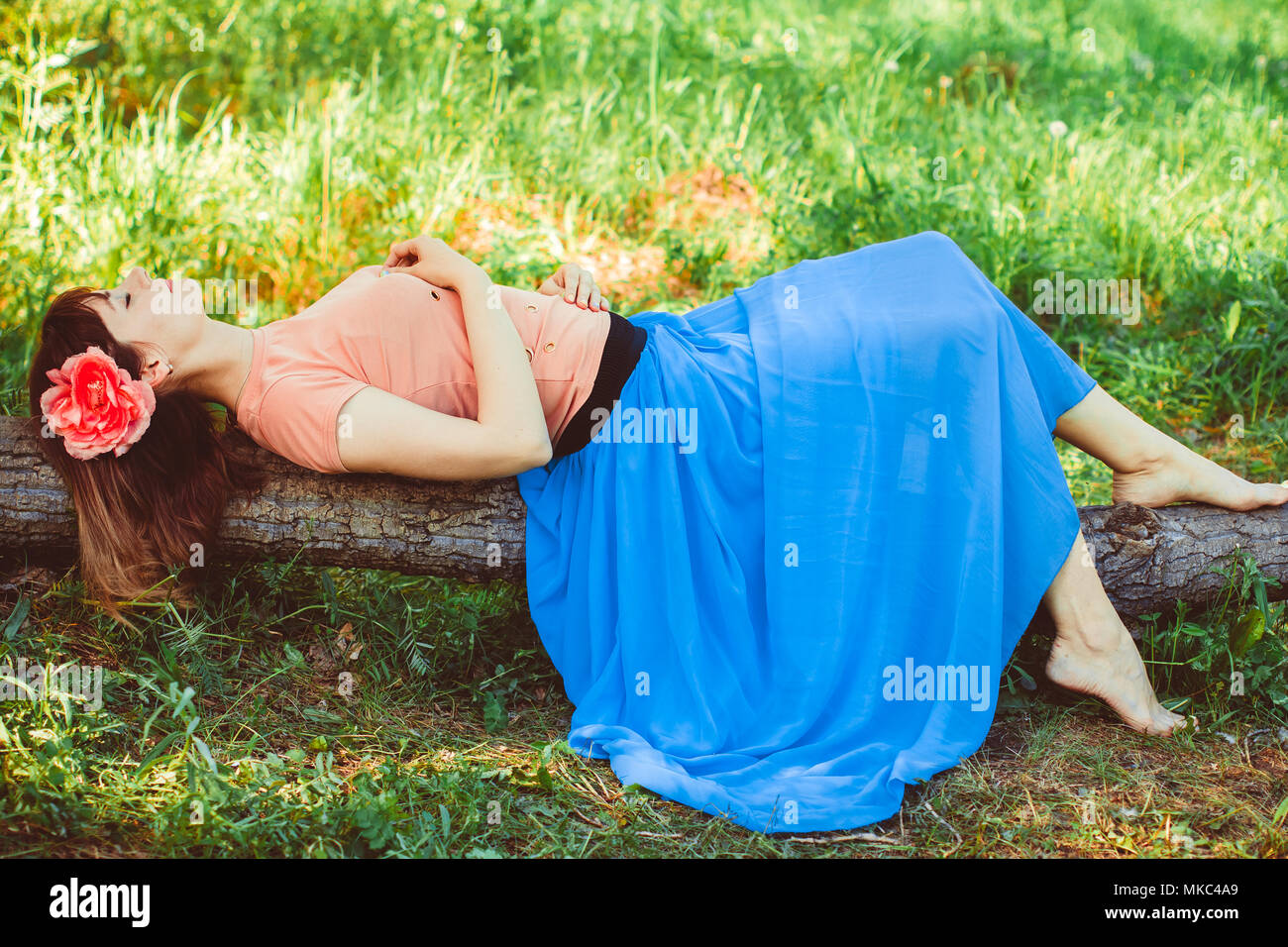 Blonde girl sitting on tree trunk hi-res stock photography and images ...