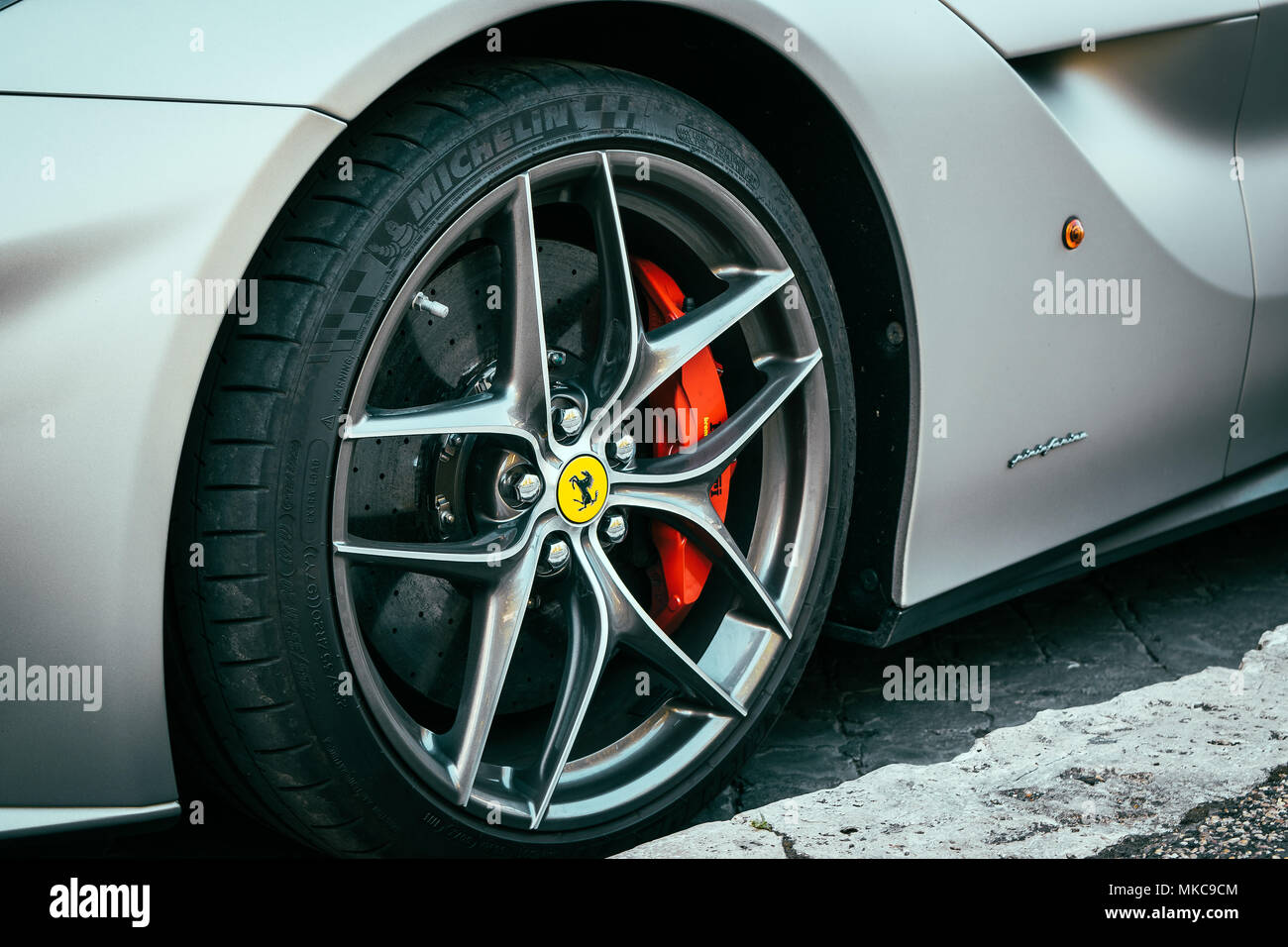 Detail of a rim with the Ferrari horse and the tire of a sport car with ...