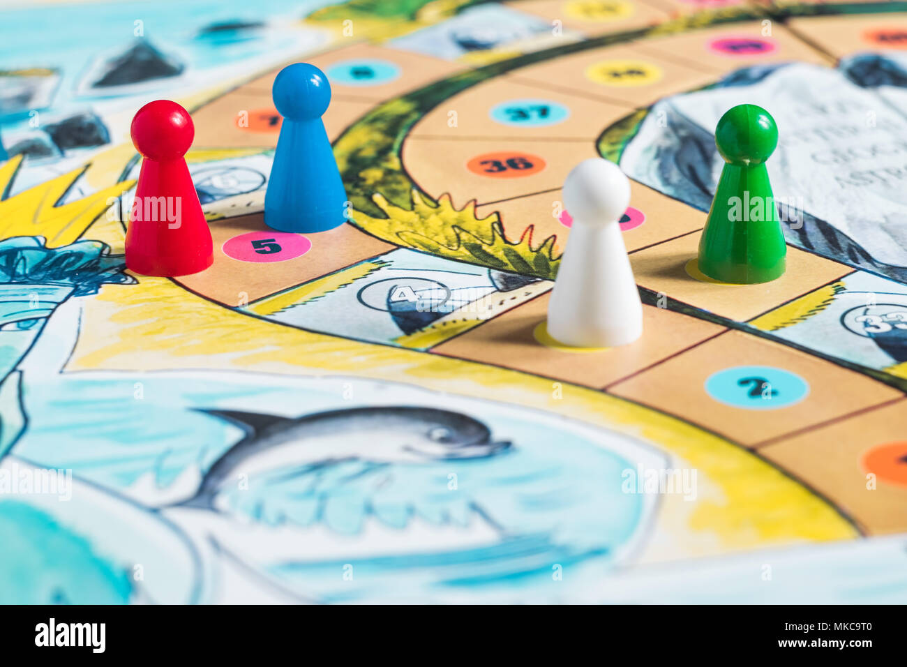 Colored pawns arranged on the board at the boxes of a board game Stock ...