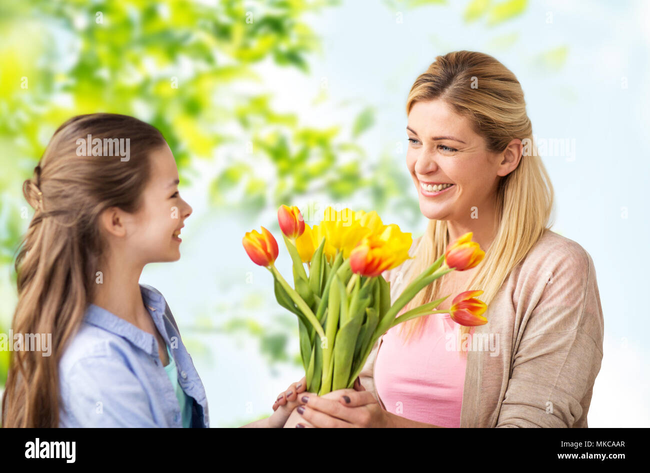 happy daughter giving flowers to mother Stock Photo - Alamy