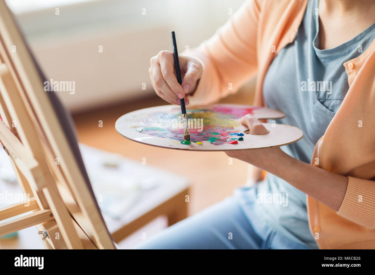 artist with palette and brush painting at studio Stock Photo - Alamy