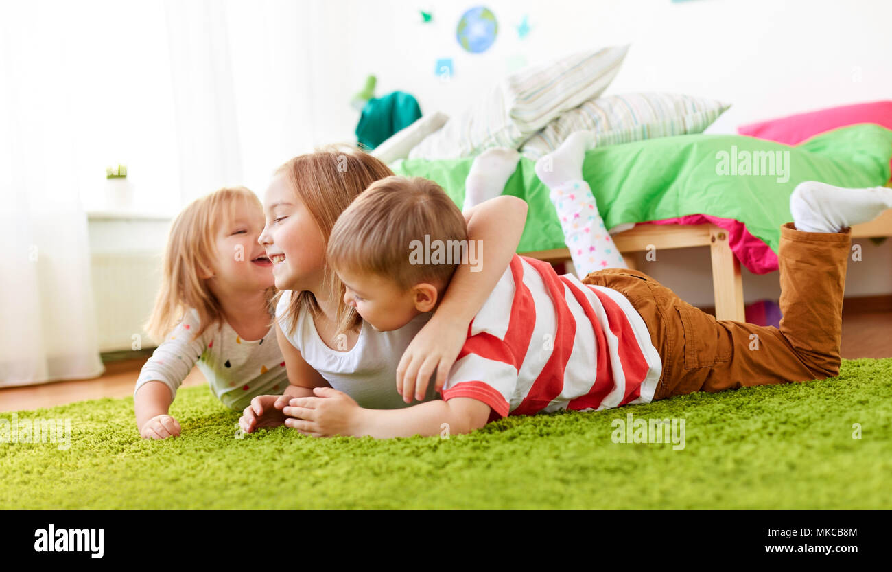 happy little kids lying on floor or carpet Stock Photo - Alamy