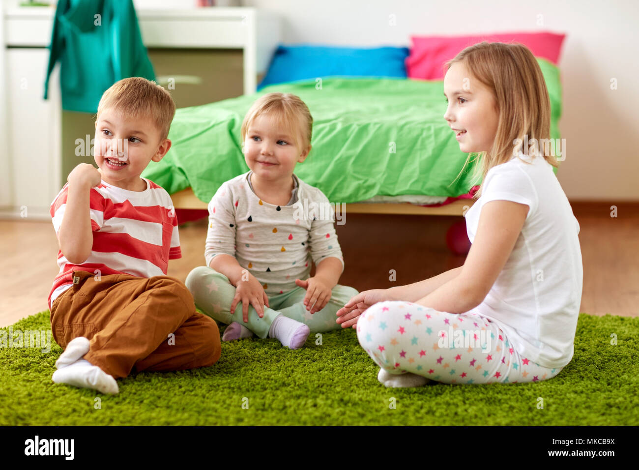 group of happy kids sitting on floor at home Stock Photo - Alamy