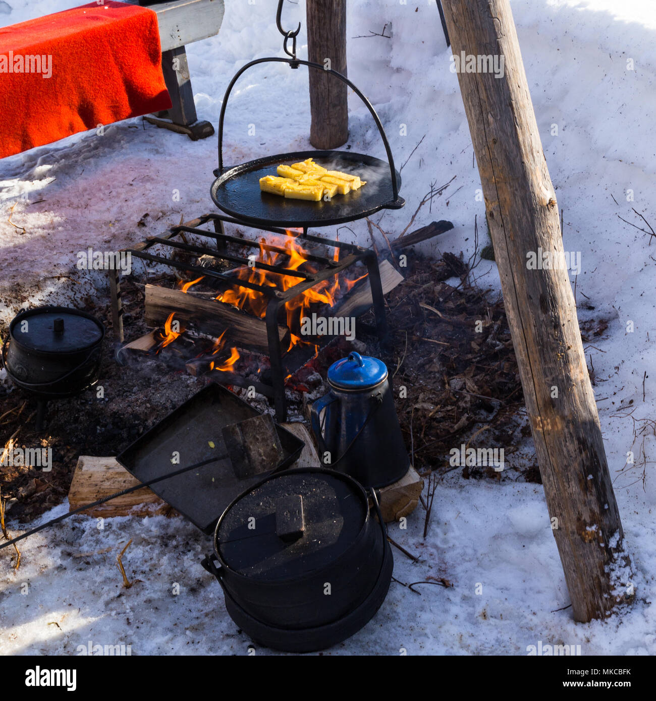 Cooking breakfast over a fire at the Sugar Bush winter encampment ...