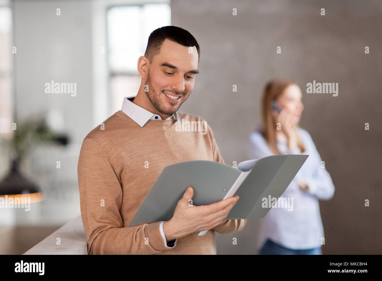 smiling male office worker with folder Stock Photo - Alamy