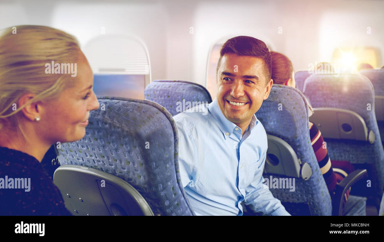 happy passengers talking in plane Stock Photo - Alamy