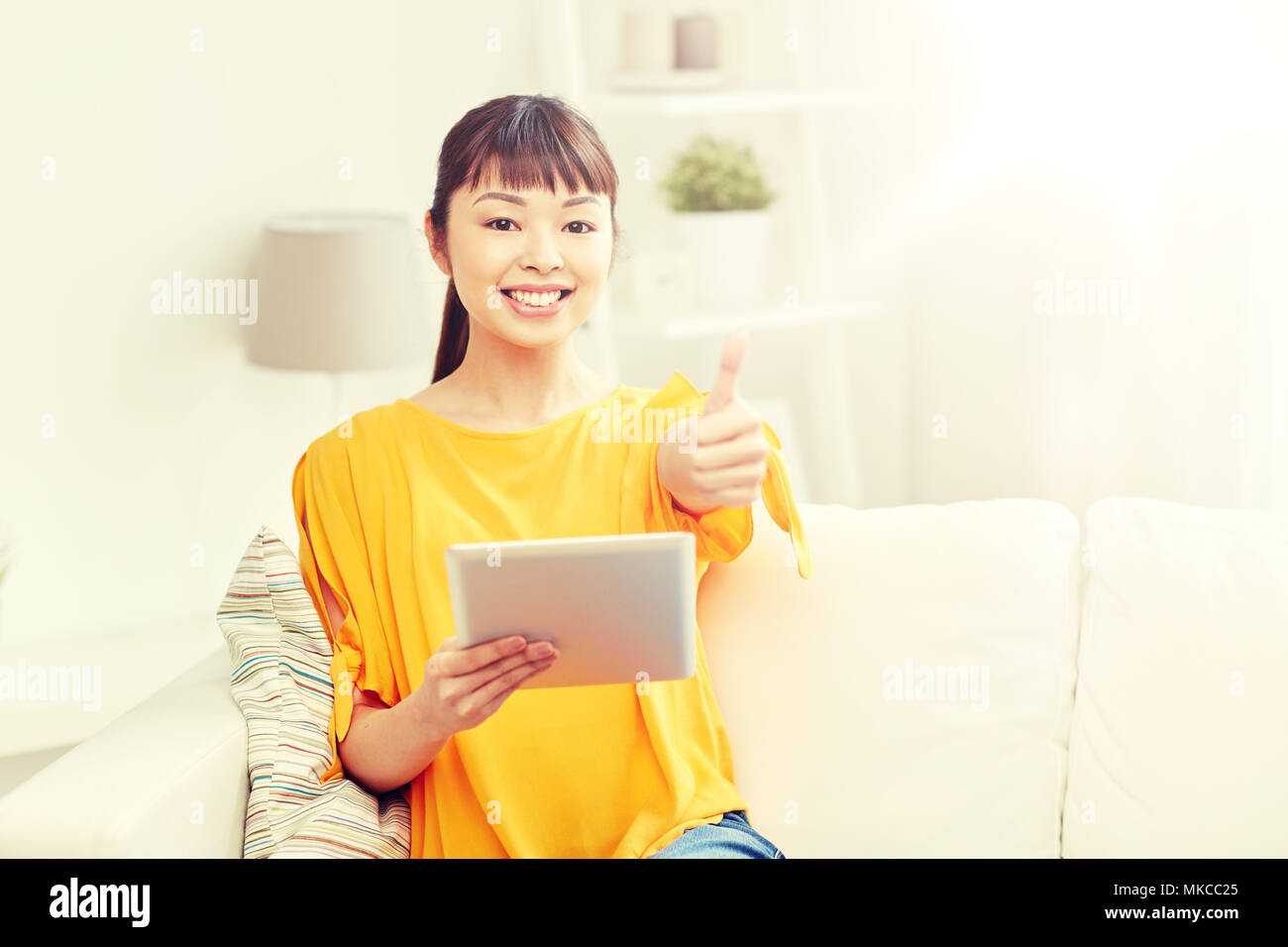 happy asian woman with tablet pc and thumbs up Stock Photo - Alamy