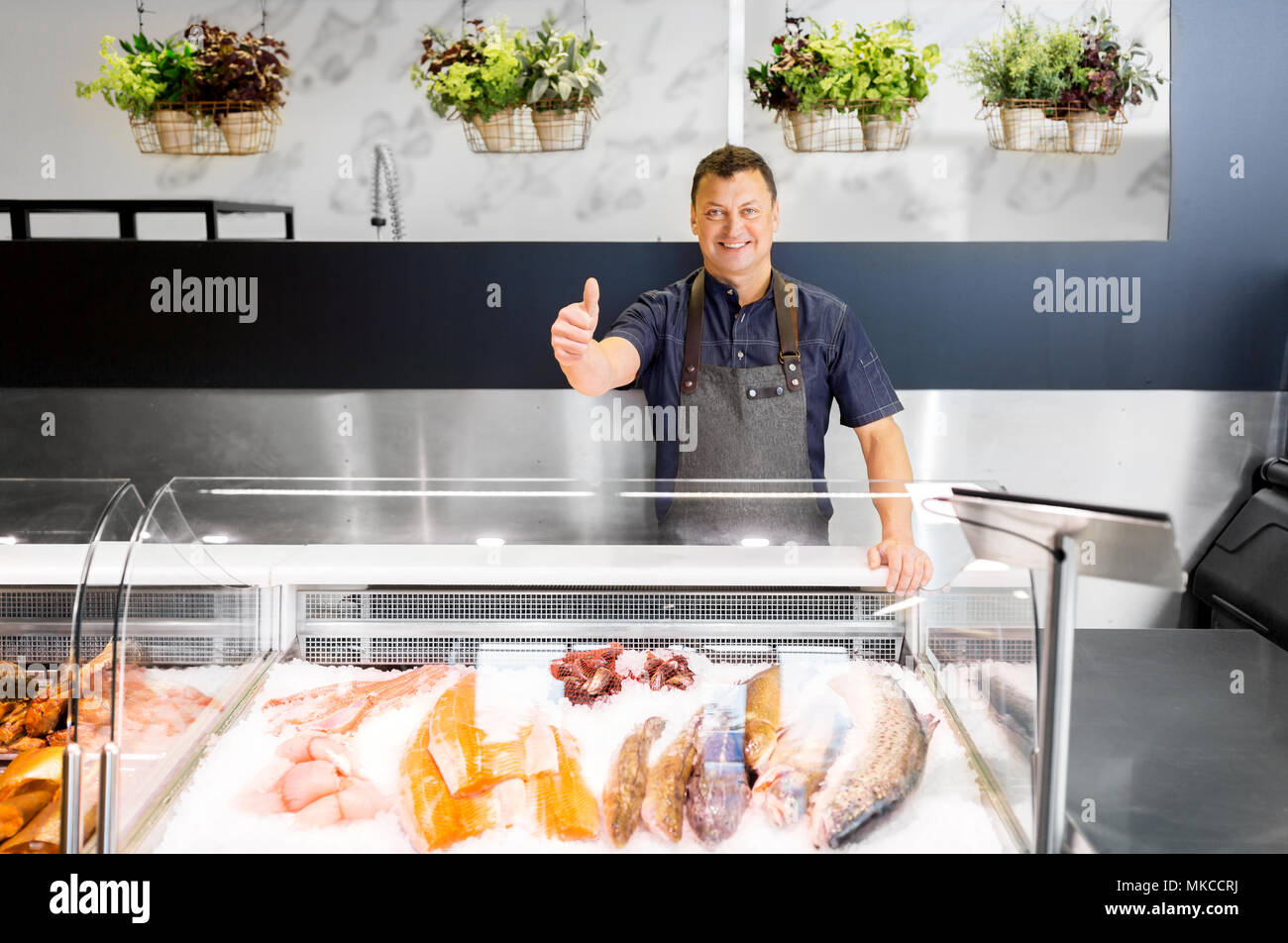 seafood seller at fish shop showing thumbs up Stock Photo - Alamy