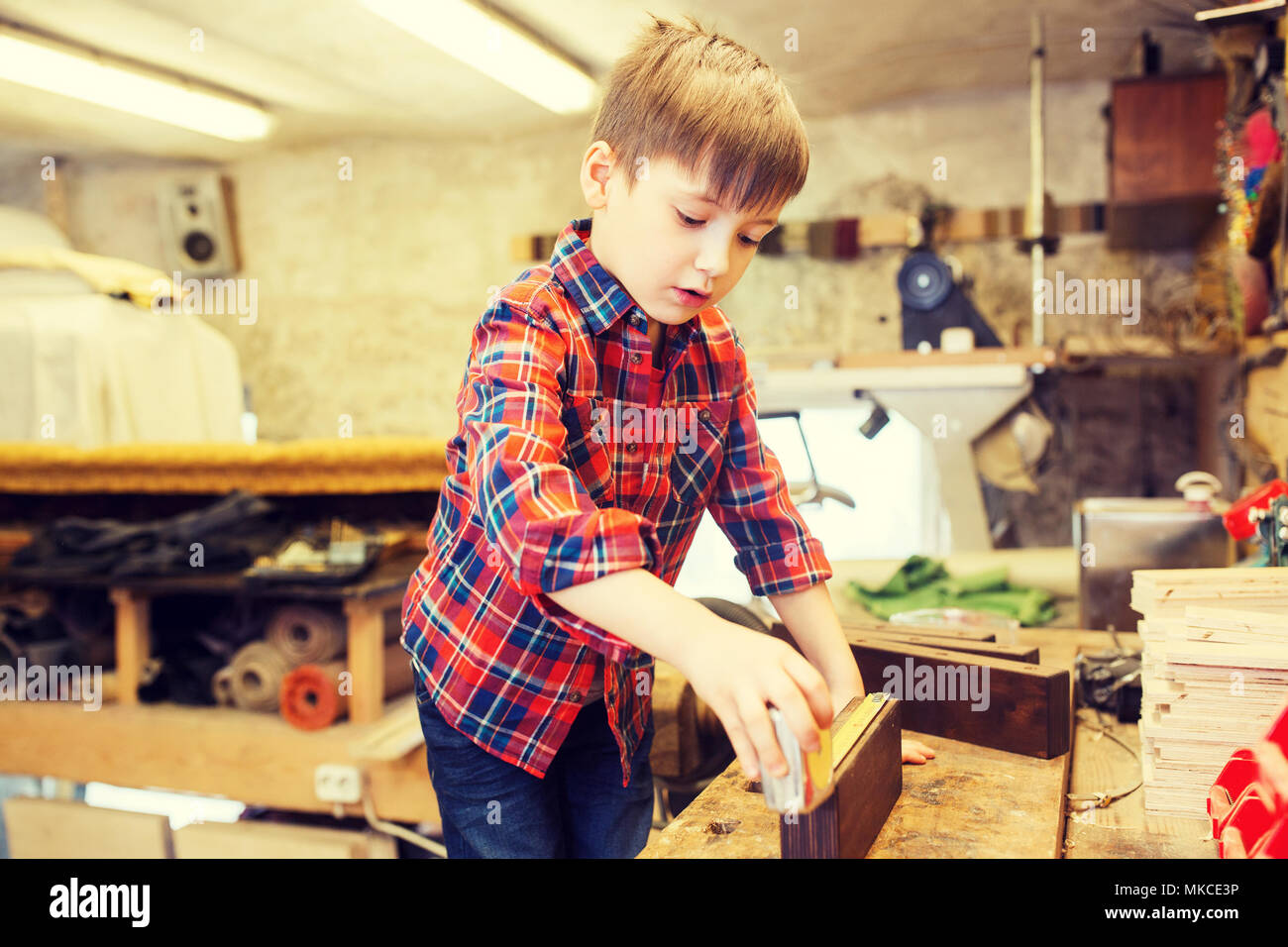 happy little boy with plank and ruler at workshop Stock Photo - Alamy