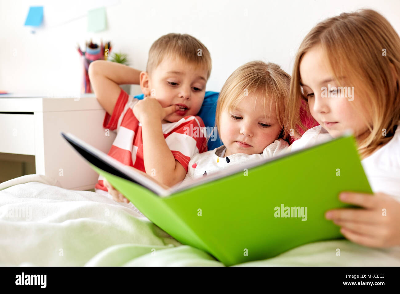 little kids reading book in bed at home Stock Photo - Alamy