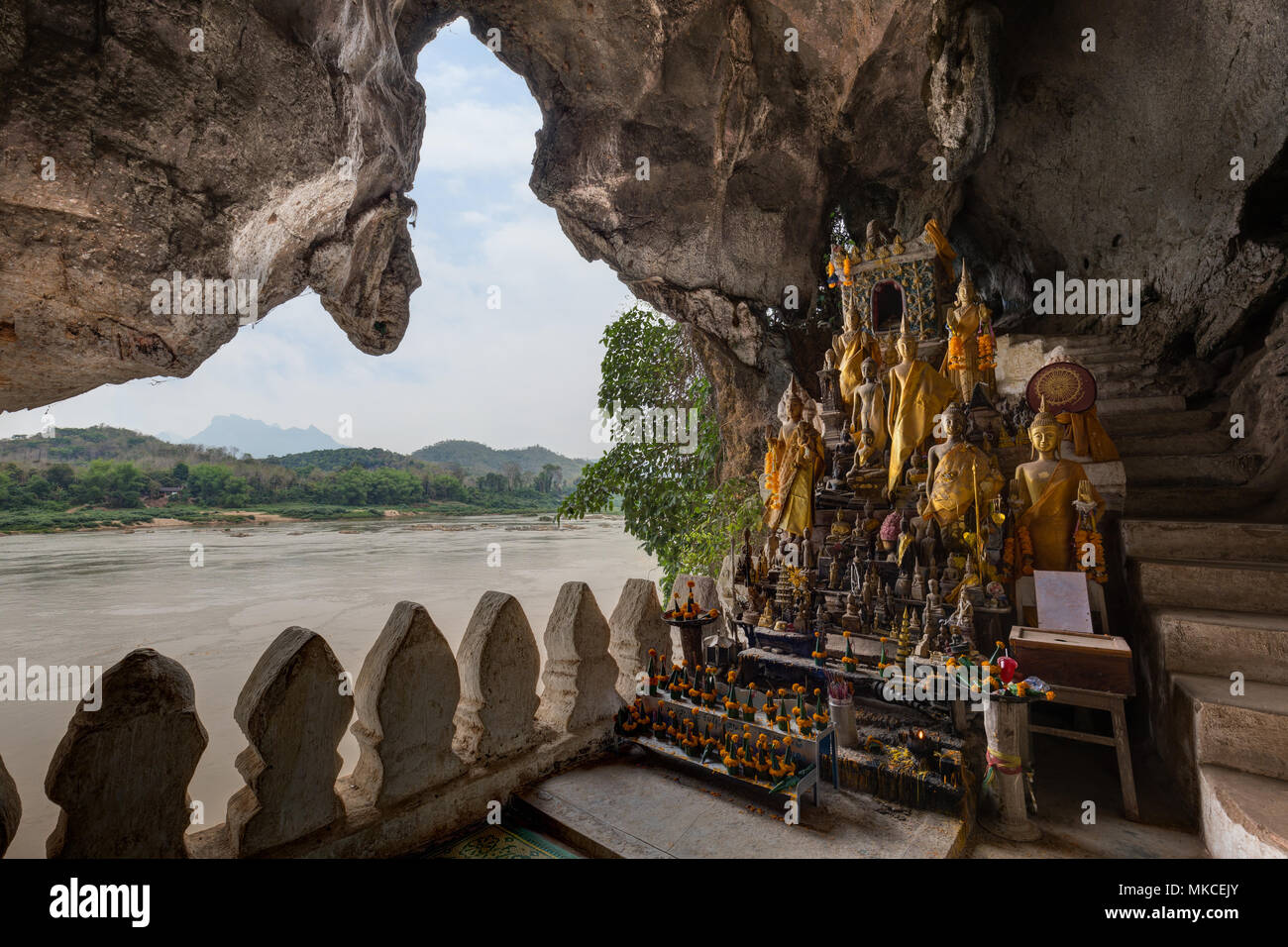 View of the Mekong River and many golden and wooden Buddha statues and ...