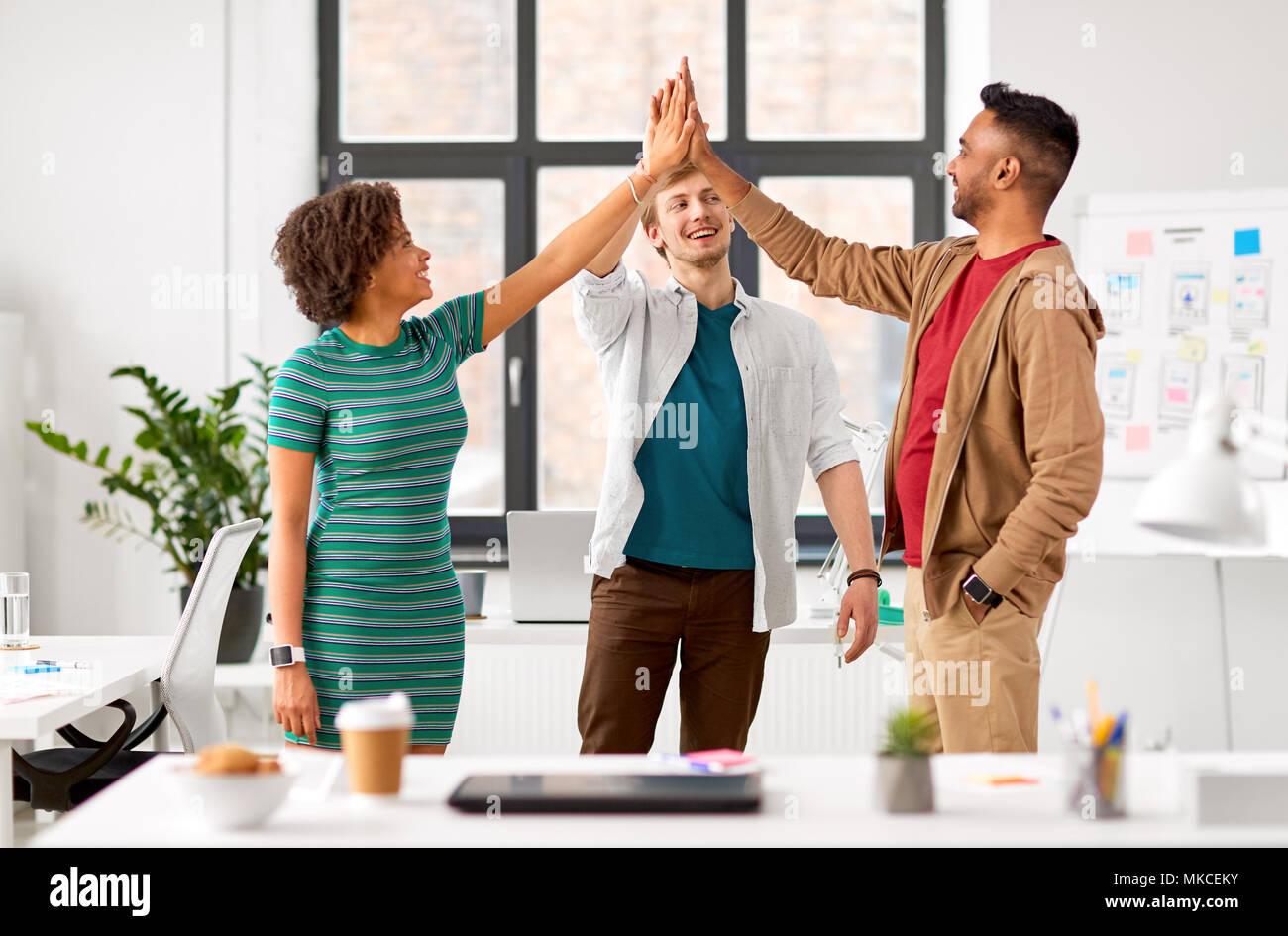 happy creative team making high five at office Stock Photo - Alamy