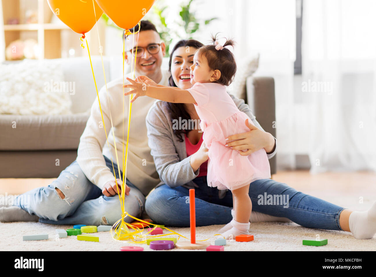 baby girl reaching to balloons at birthday party Stock Photo - Alamy