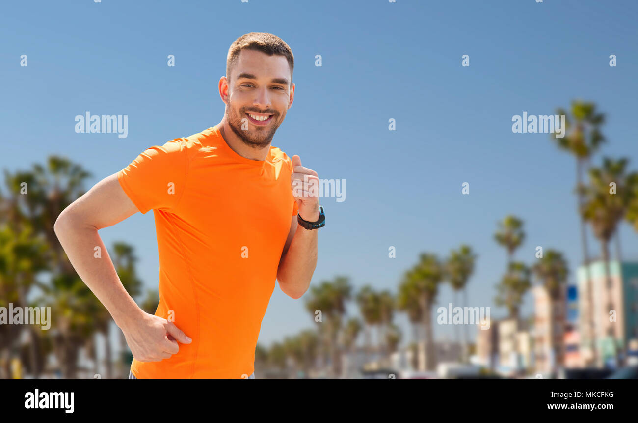smiling young man running at summer seaside Stock Photo - Alamy