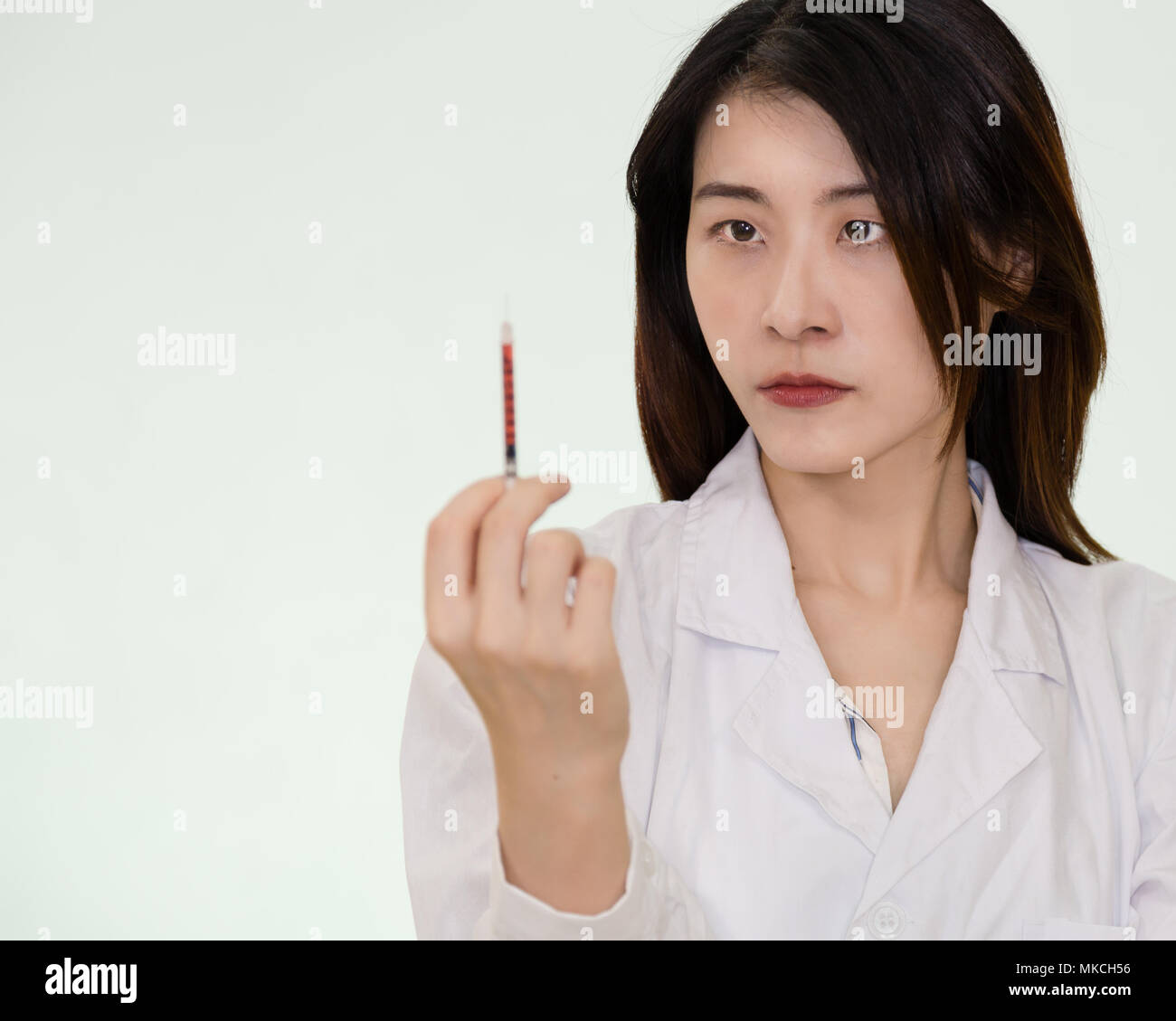 Asian nurse holding a blood-filled syringe in hand Stock Photo - Alamy