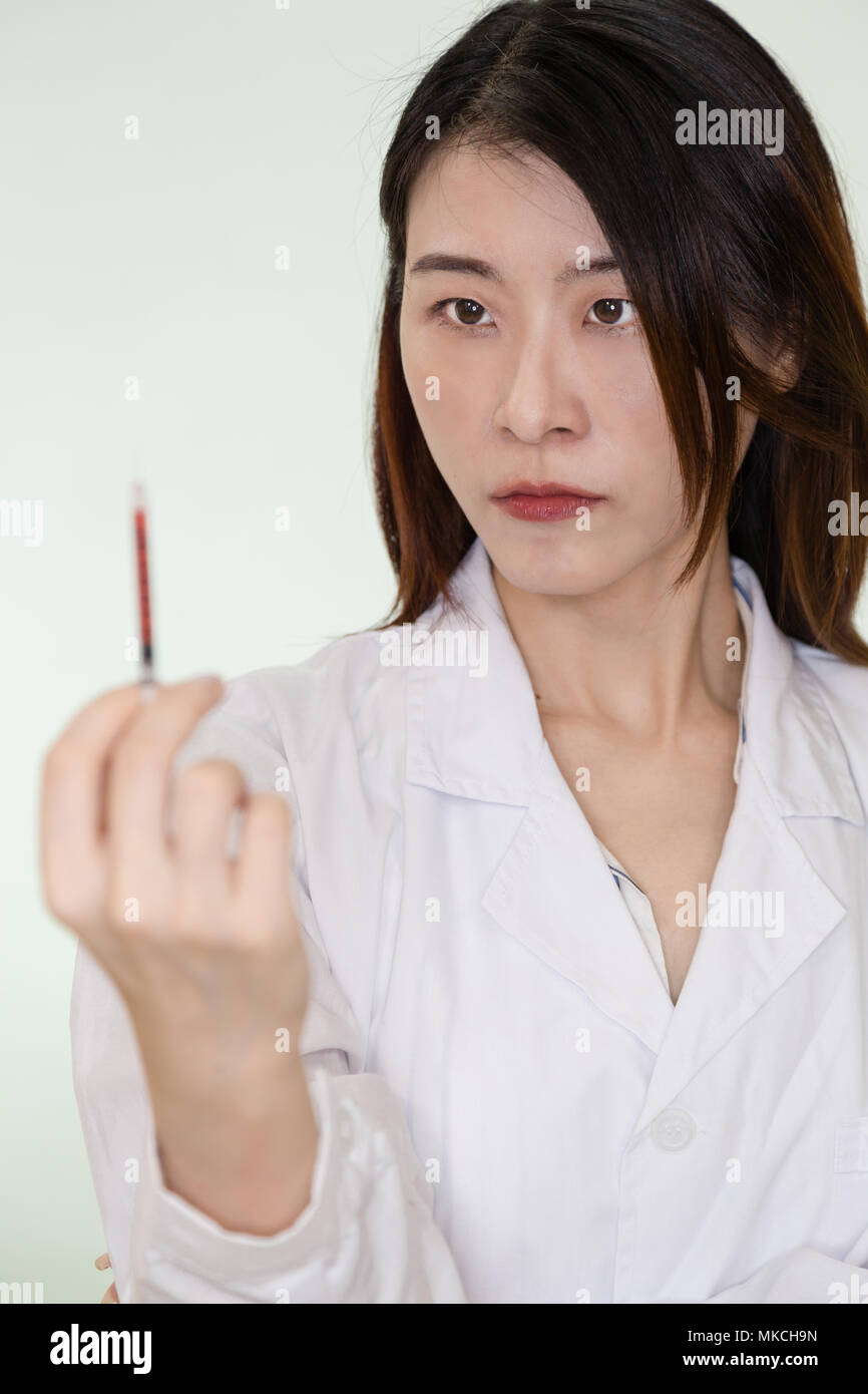 Asian nurse holding a blood-filled syringe in hand Stock Photo - Alamy