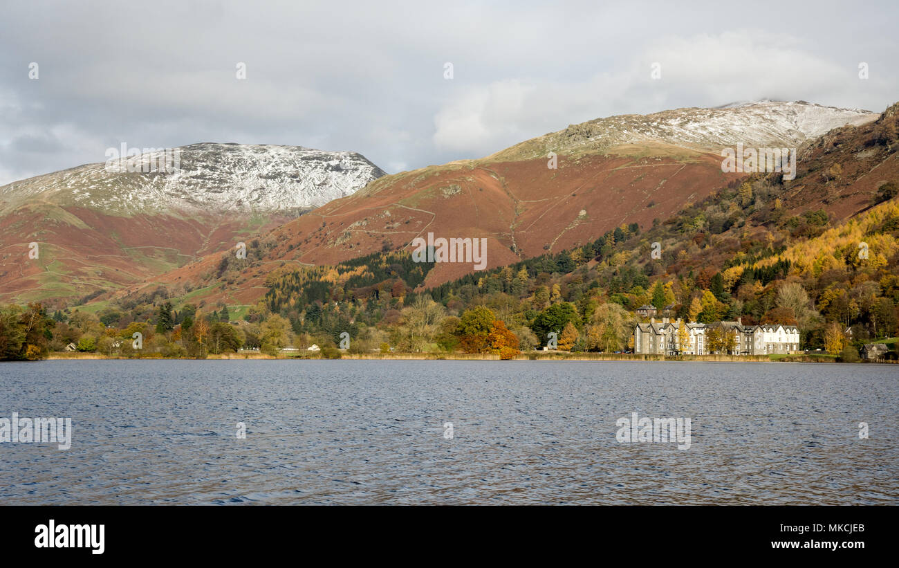The snow-capped mountain of Seat Sandal rises behind Grasmere lake in ...