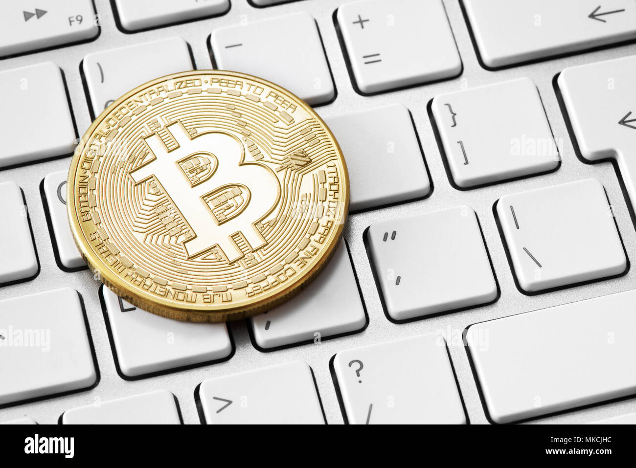Golden Bitcoin on keyboard. Physical bit coin. Digital currency ...