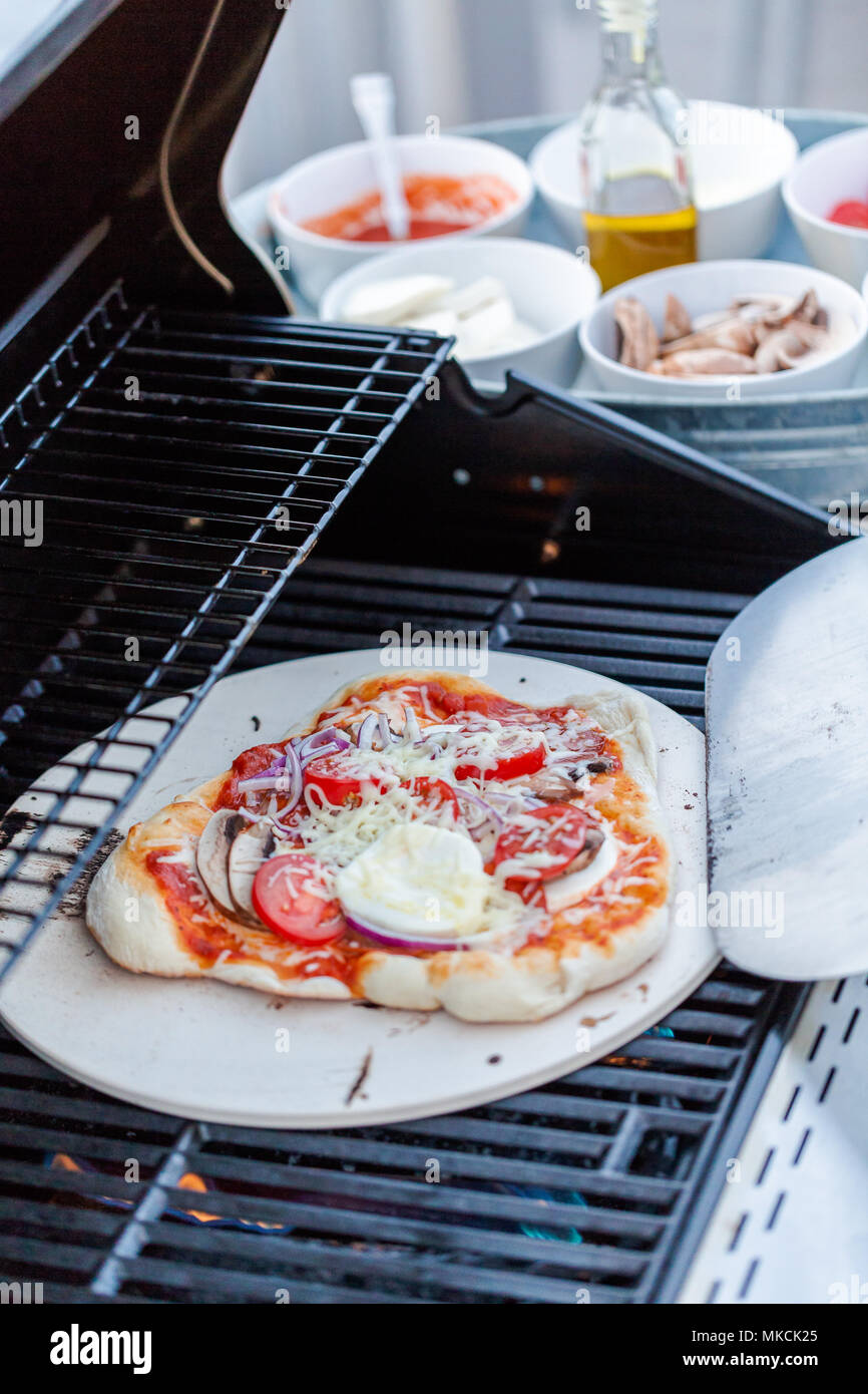 Cooking pizza on outdoor gas grill Stock Photo - Alamy