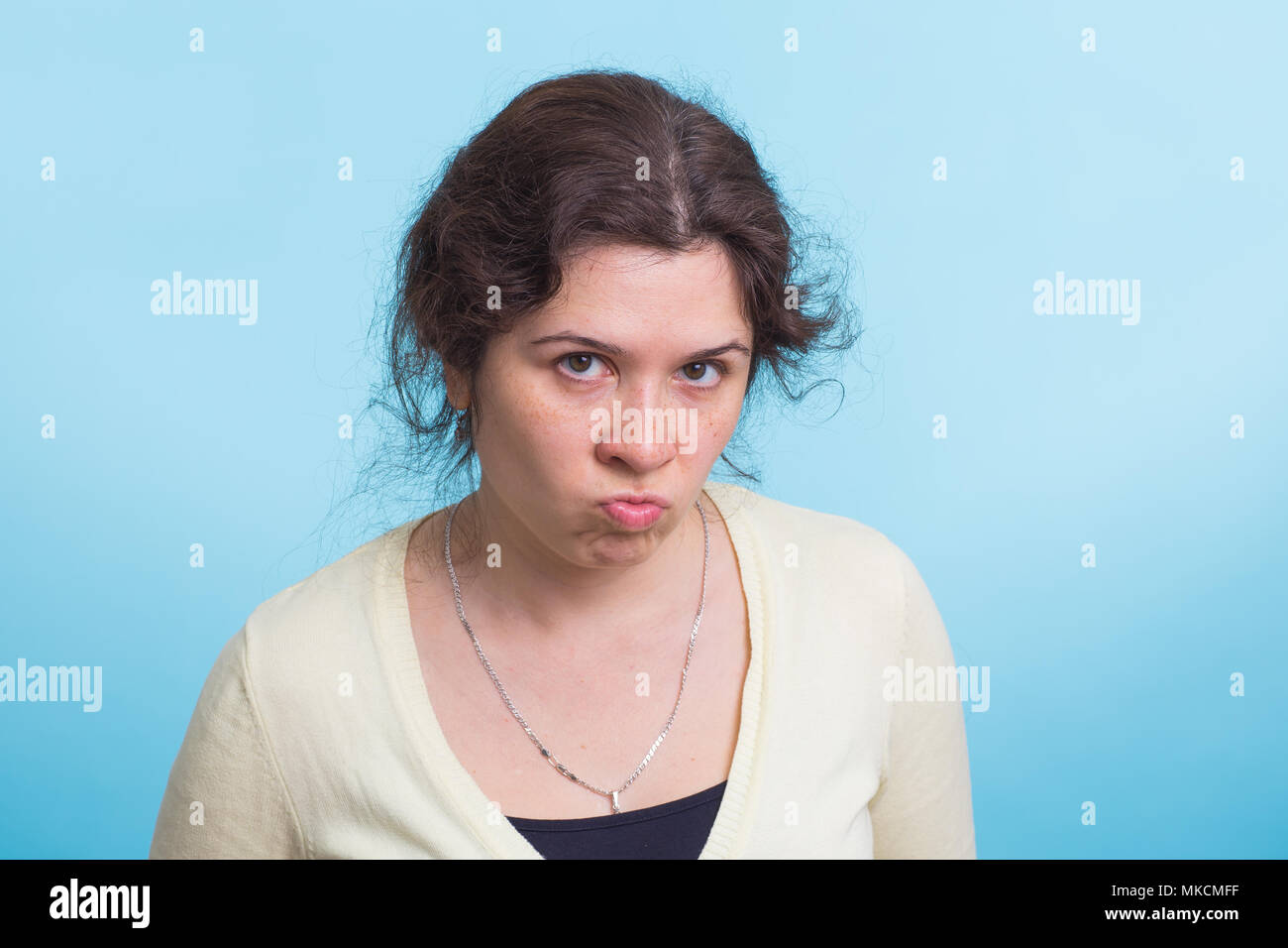 portrait of young angry woman on blue background Stock Photo - Alamy