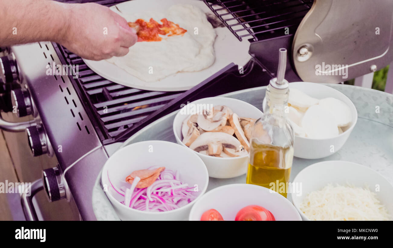 Cooking pizza on outdoor gas grill Stock Photo - Alamy