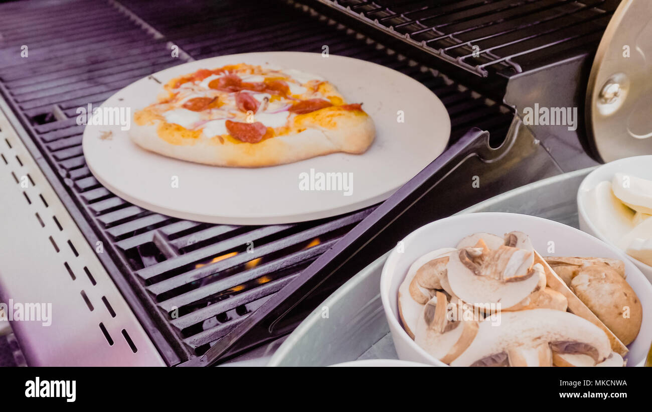 Cooking pizza on outdoor gas grill Stock Photo - Alamy