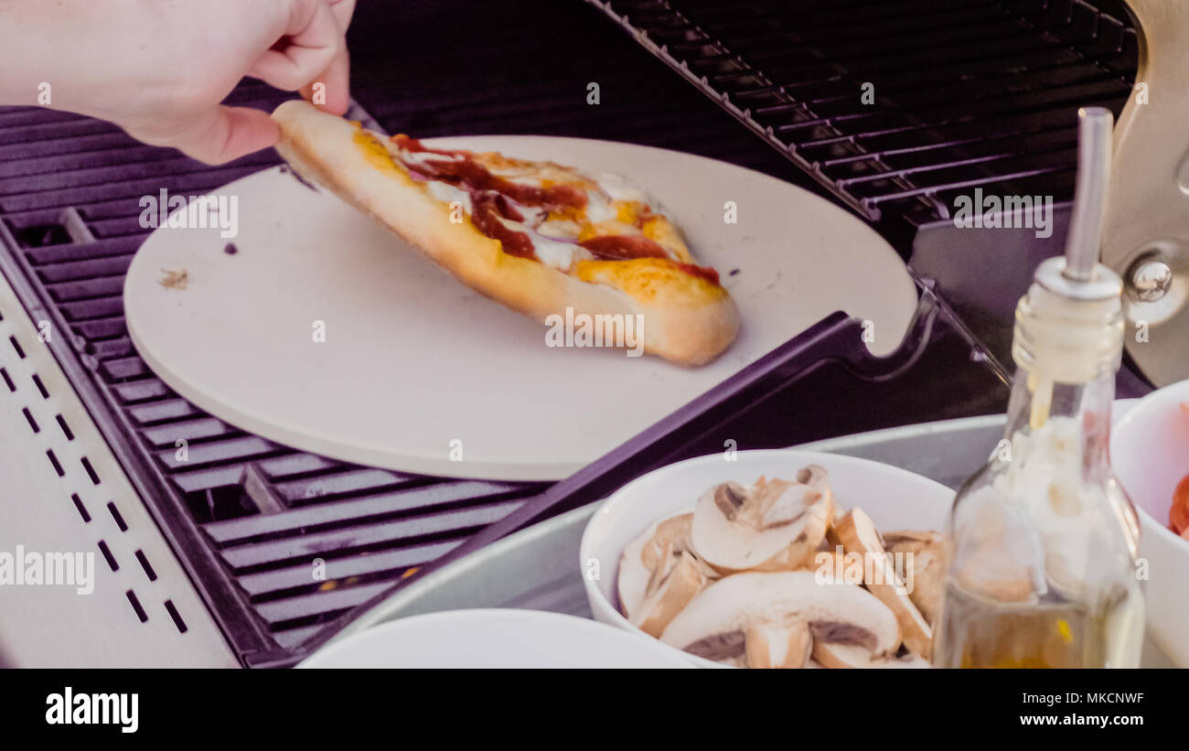 Cooking pizza on outdoor gas grill Stock Photo - Alamy