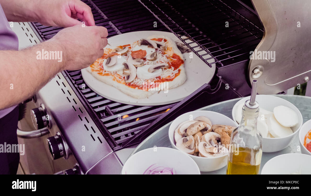 Cooking pizza on outdoor gas grill Stock Photo - Alamy