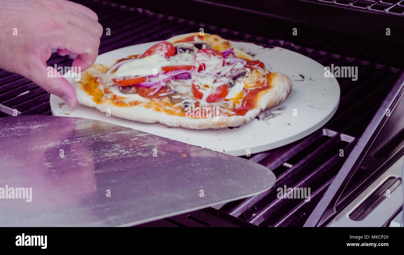 Cooking pizza on outdoor gas grill Stock Photo - Alamy