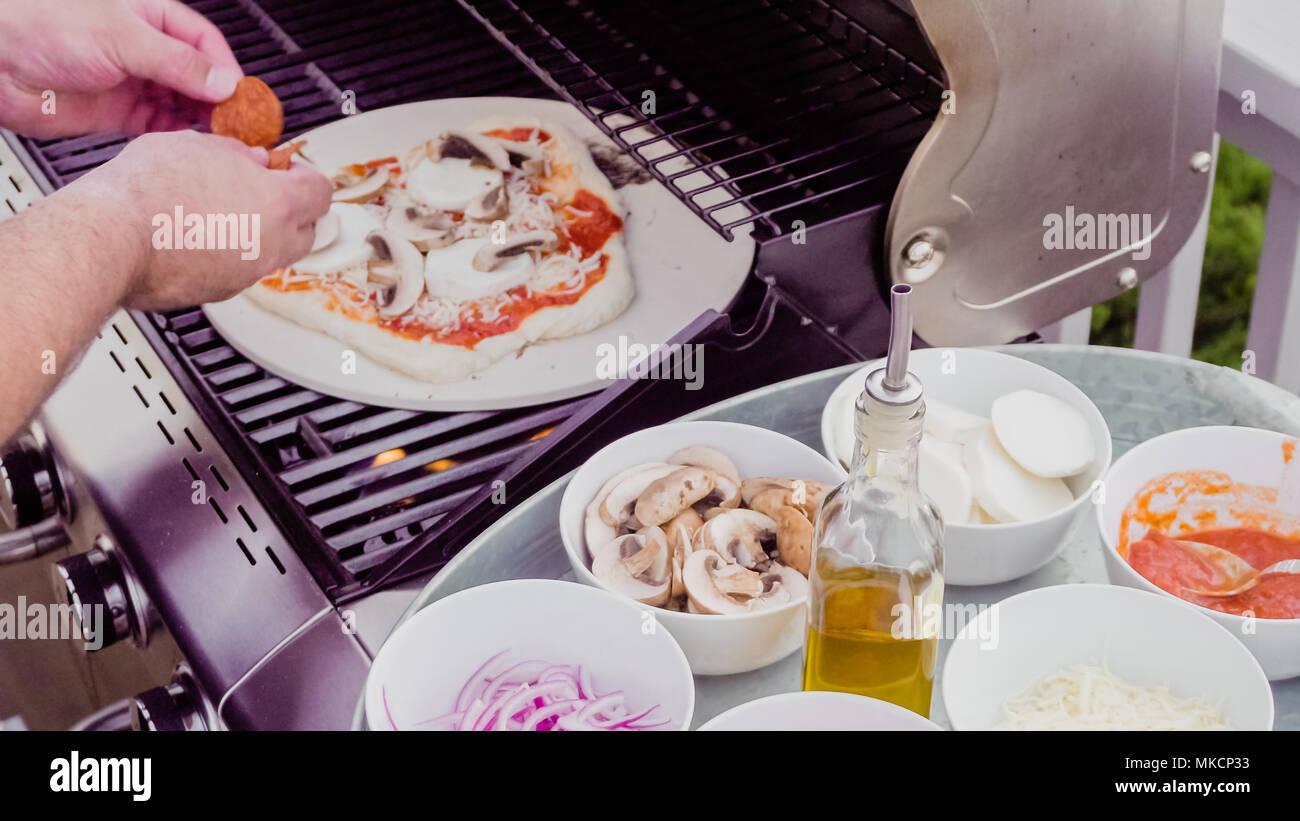 Cooking pizza on outdoor gas grill Stock Photo - Alamy