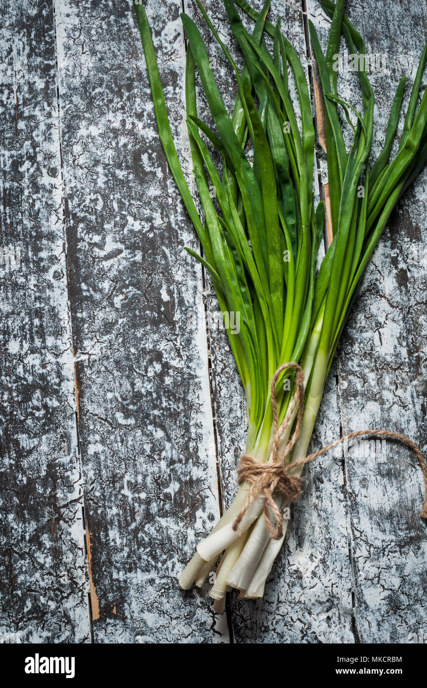 bunch of spring onion on a wood table Stock Photo - Alamy