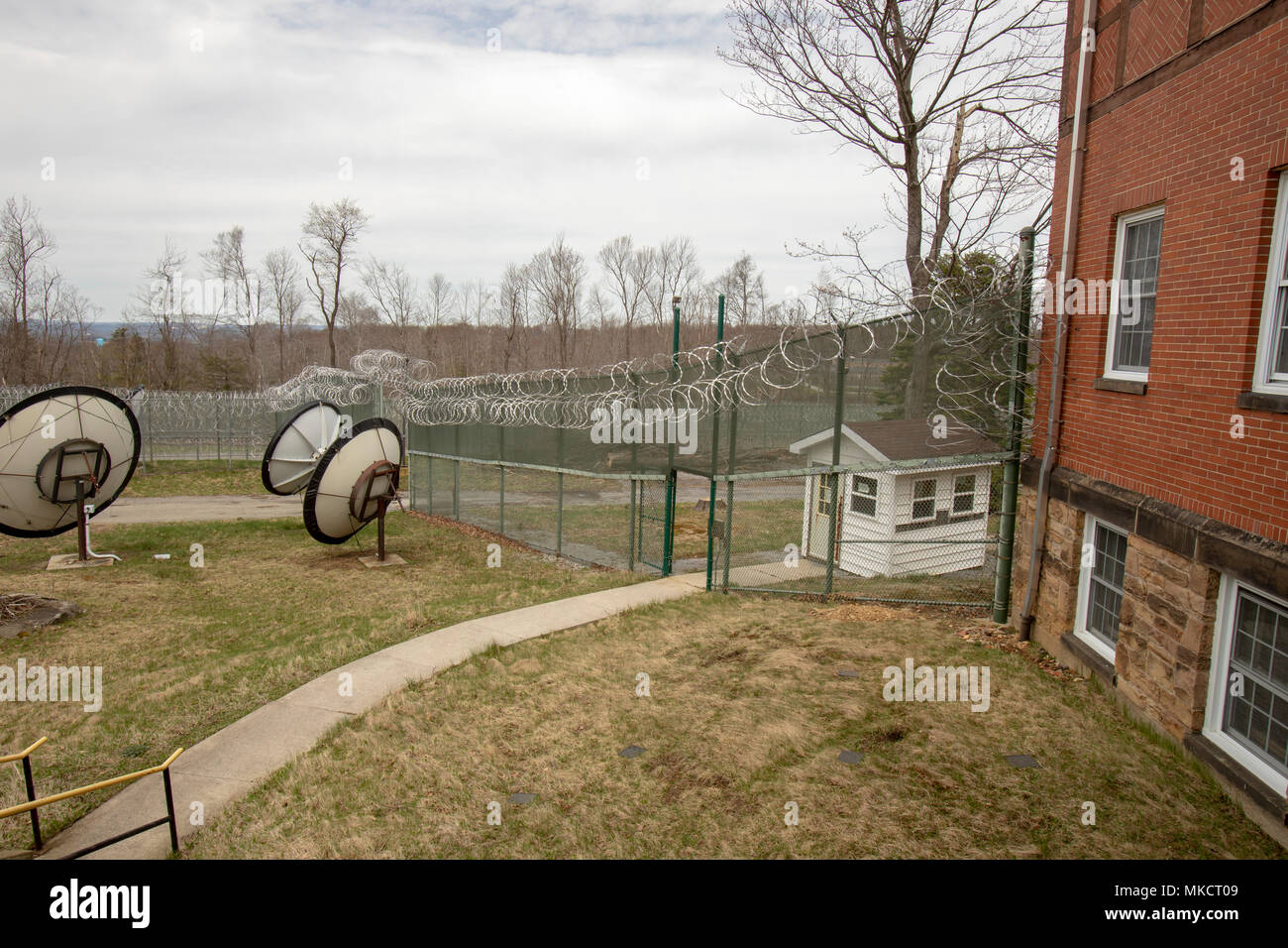 Guard station at gate in fence covered in razor wire on grounds of old ...
