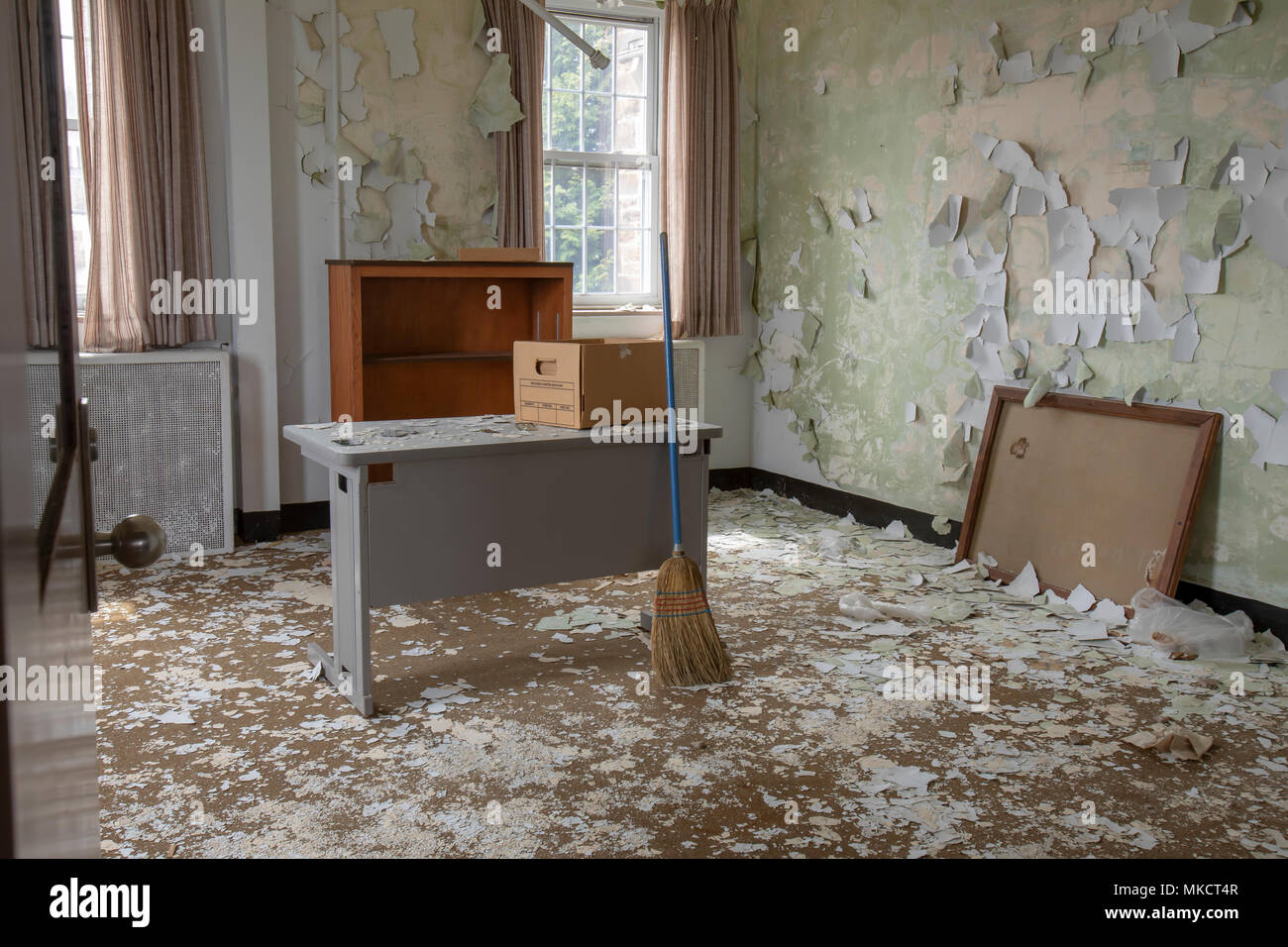 Interior of abandoned office with peeling paint desk and bookshelves ...