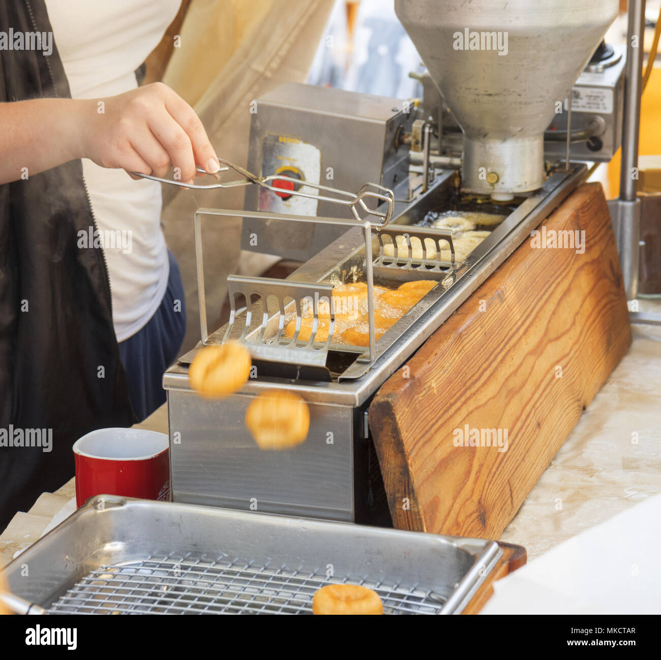 Street food market. Vendors at the street market make fresh donuts ...