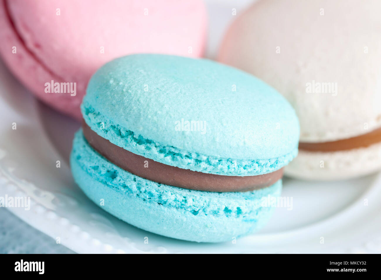 Three macaroons of different colors and different tastes in a white ...