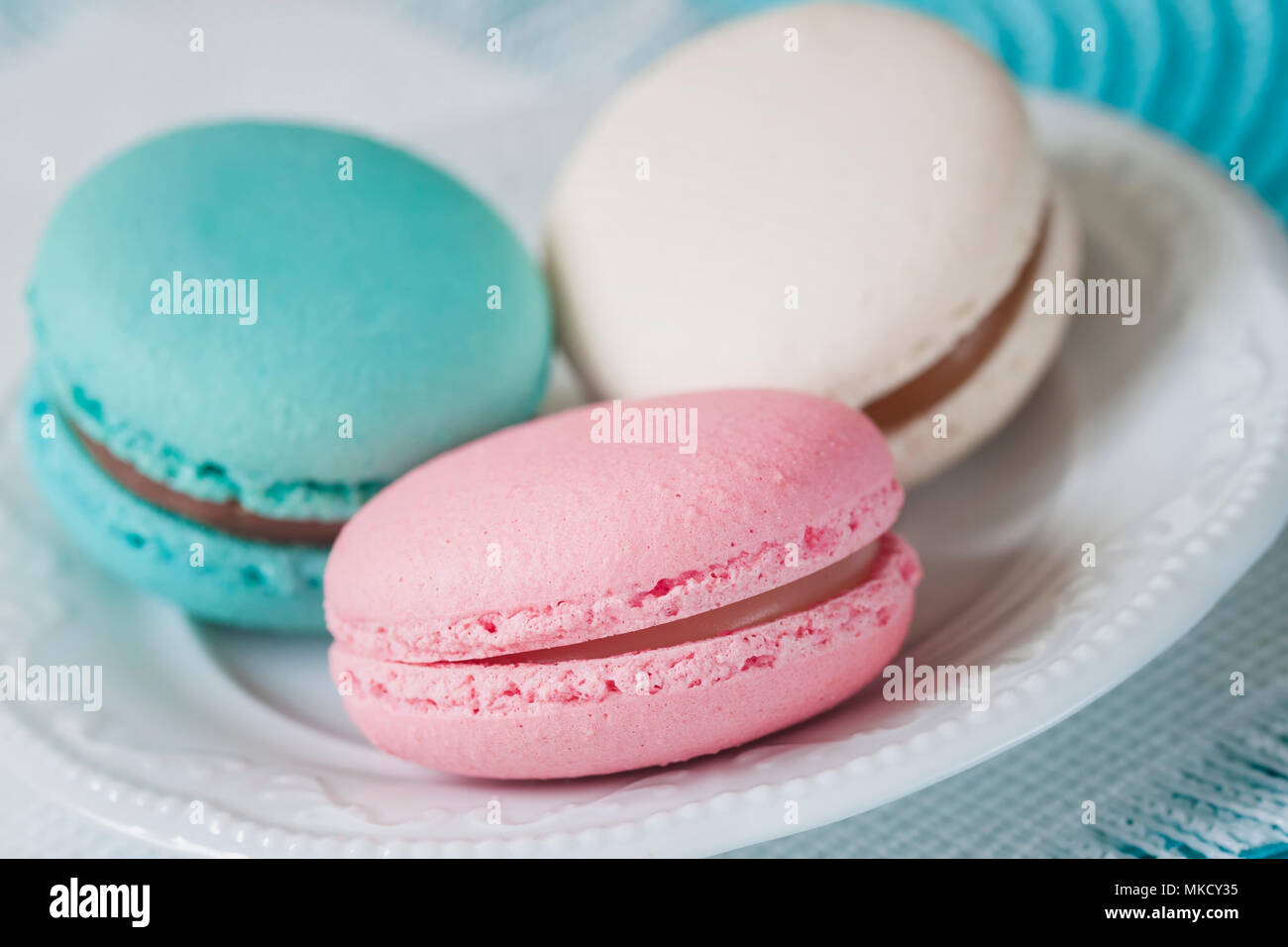 Three macaroons of different colors and different tastes in a white ...