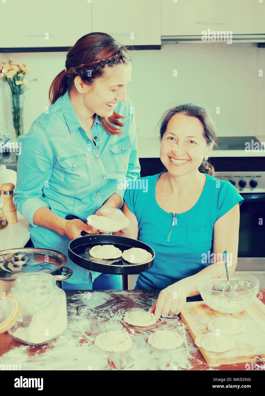 Two laughing women making pies together Stock Photo - Alamy