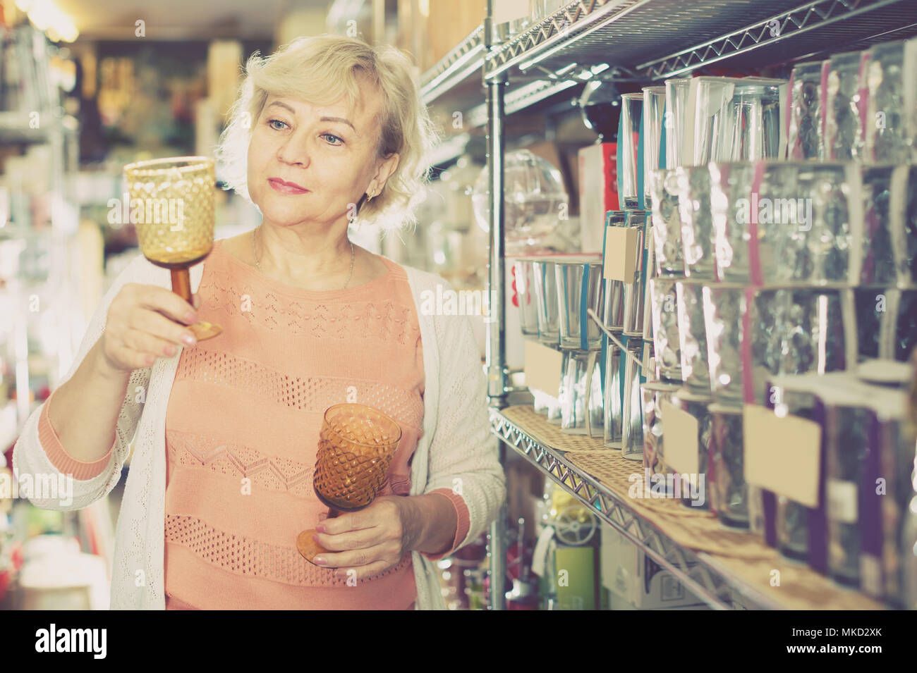 adult customer woman choosing wineglass for drink in the dishes shop ...