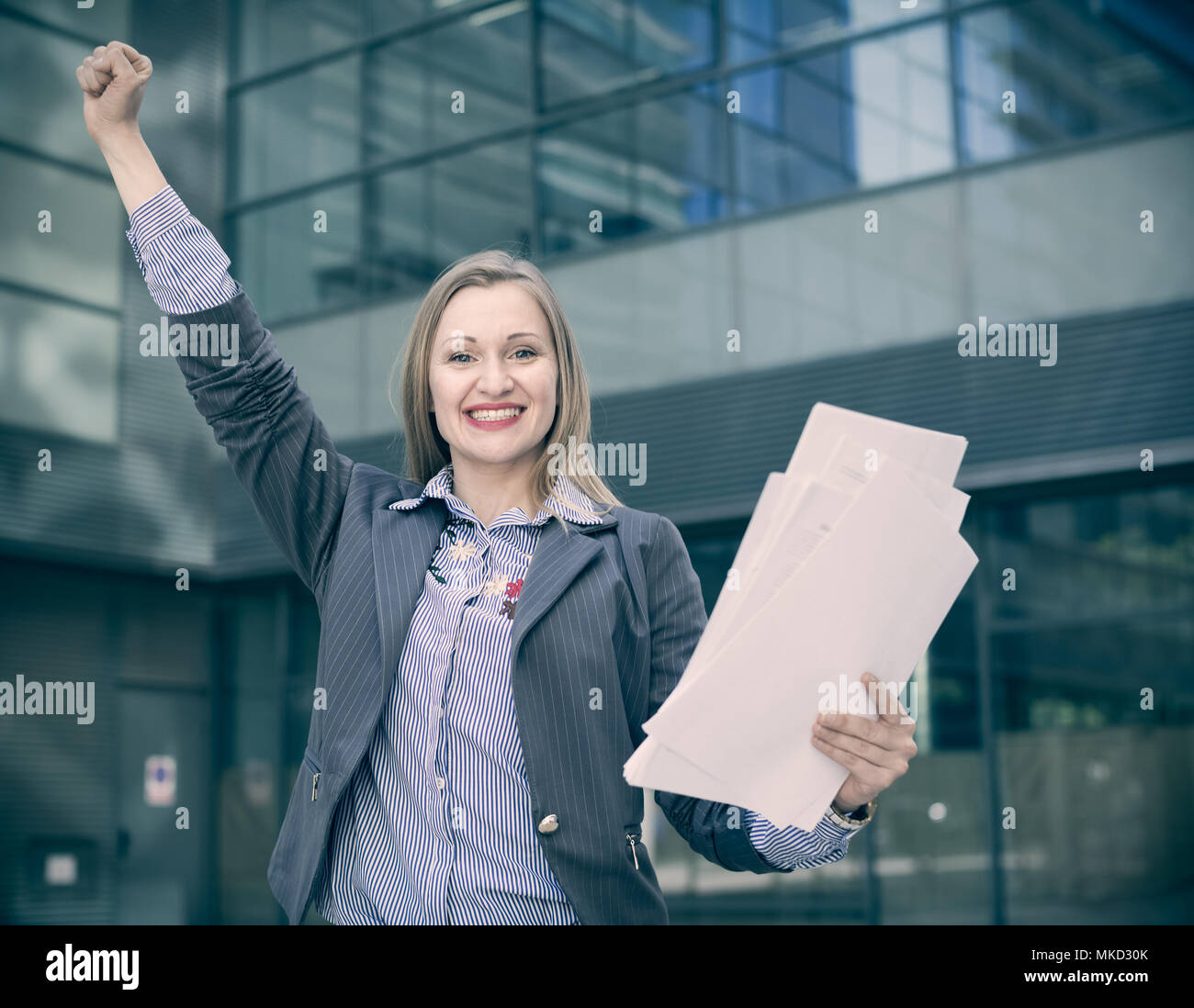 Employee glad woman in suit standing with paper documents at the city ...