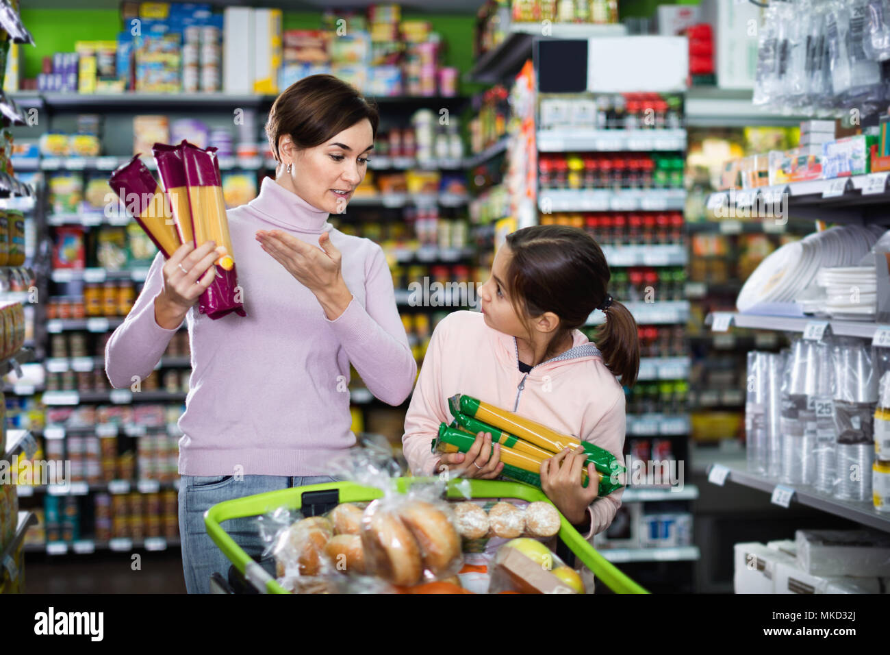 Glad cheerful positive female shopper with teenage daughter searching ...