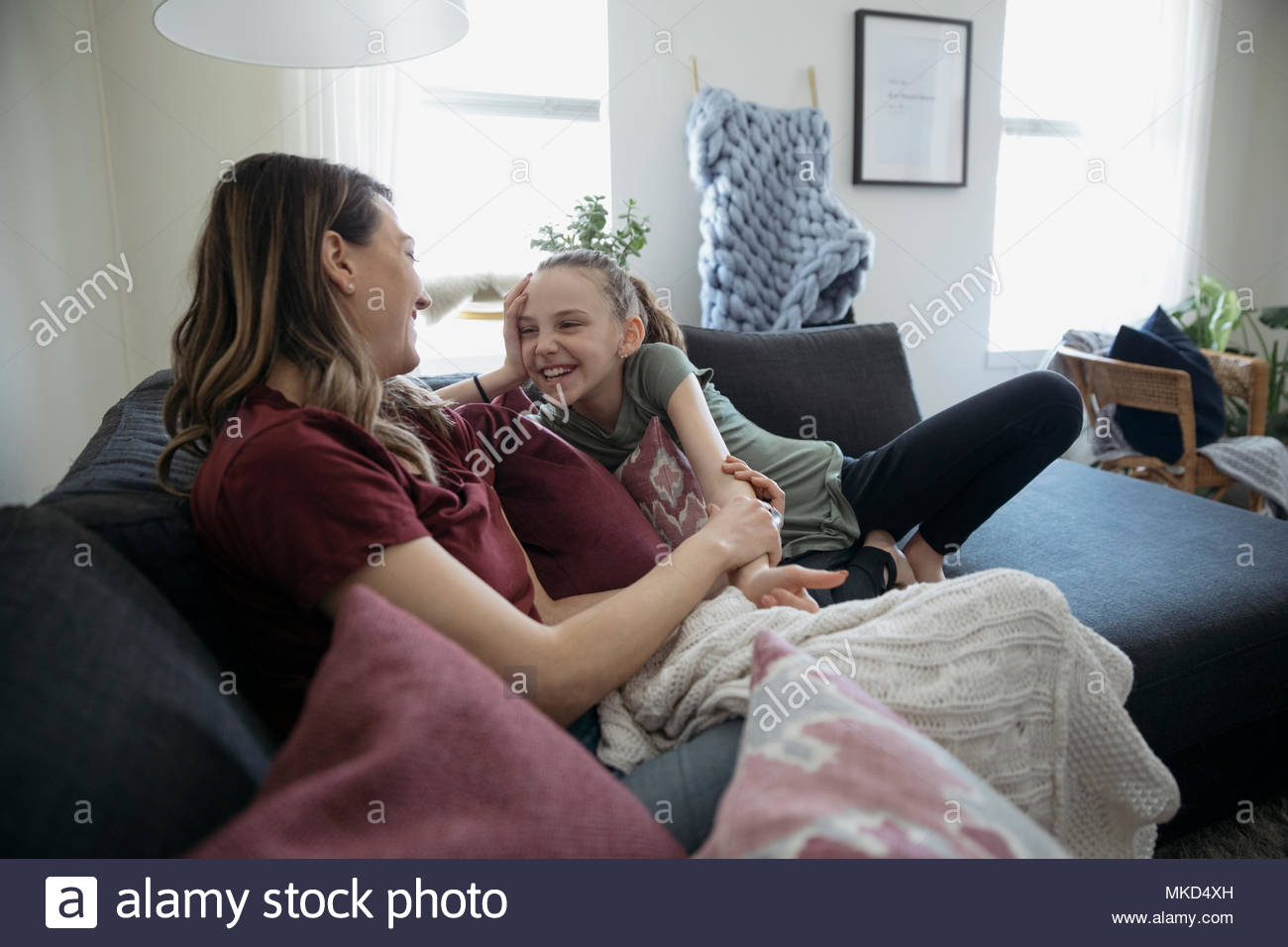 Affectionate Mother And Daughter Bonding Talking On Living Room Sofa