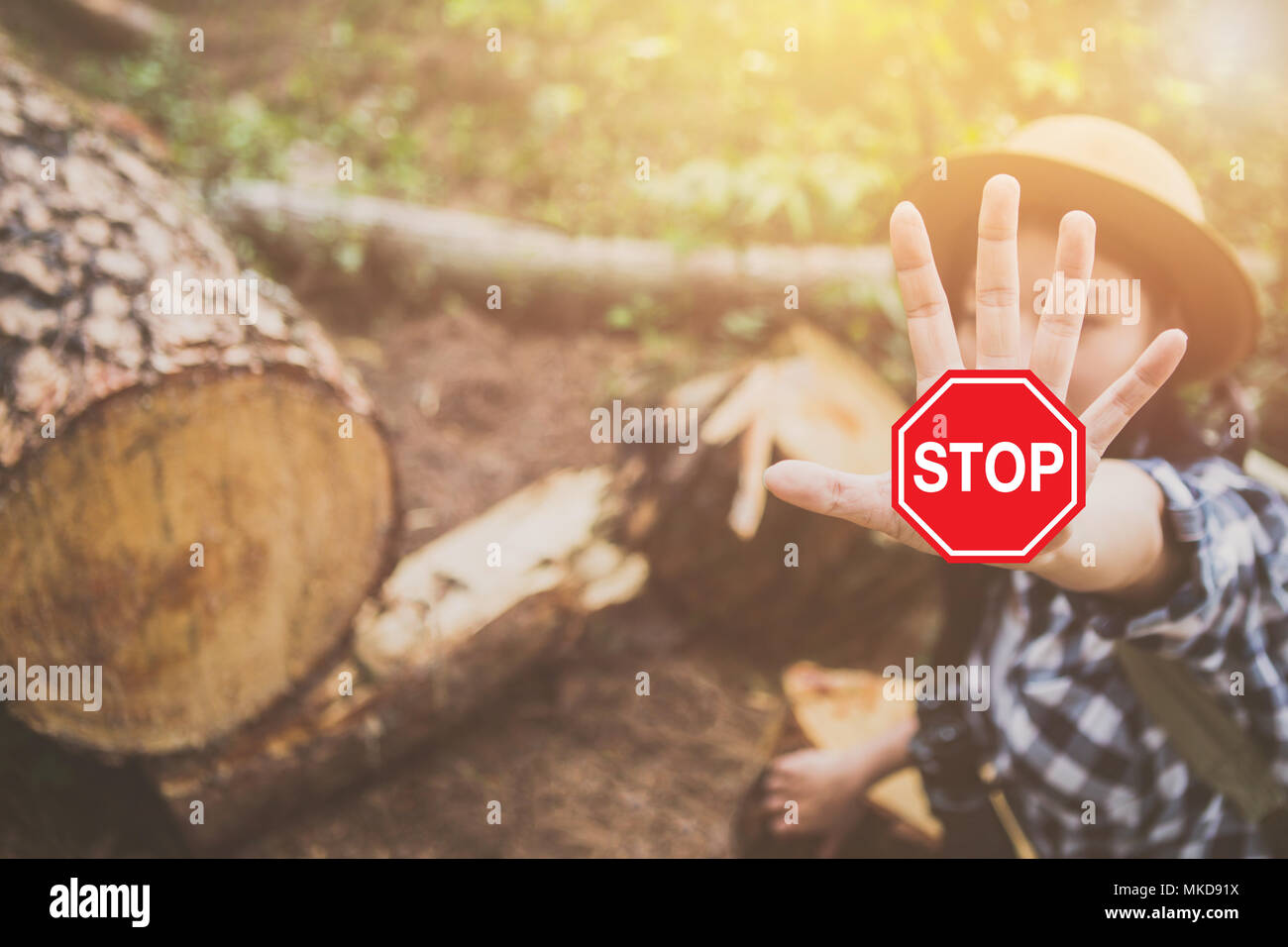 Deforestation,A young woman lifts a stop sign Stock Photo - Alamy