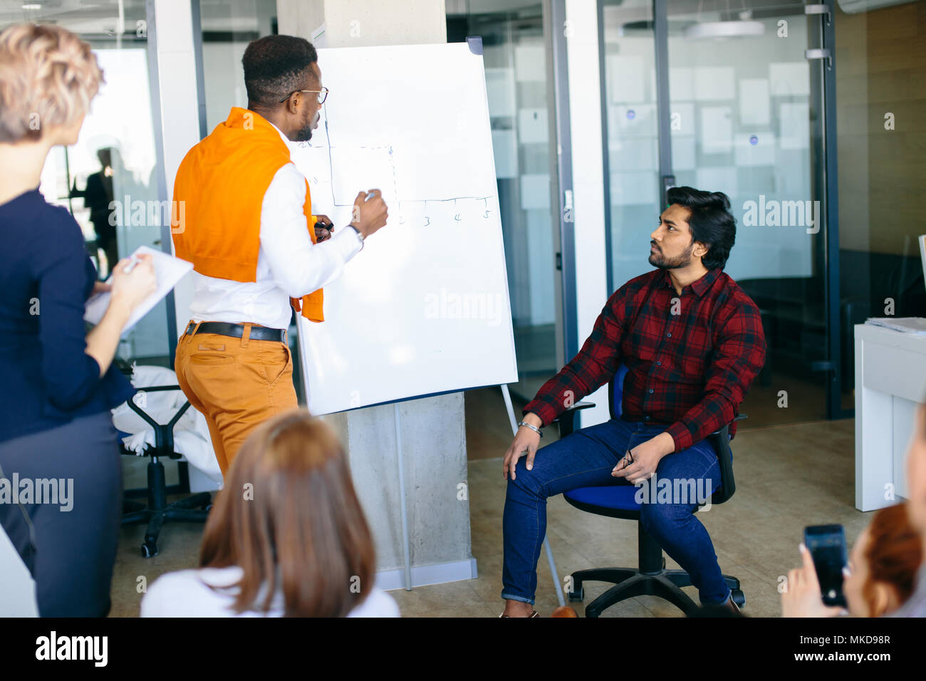 close up image of african office manager showing chart on flipchart to ...