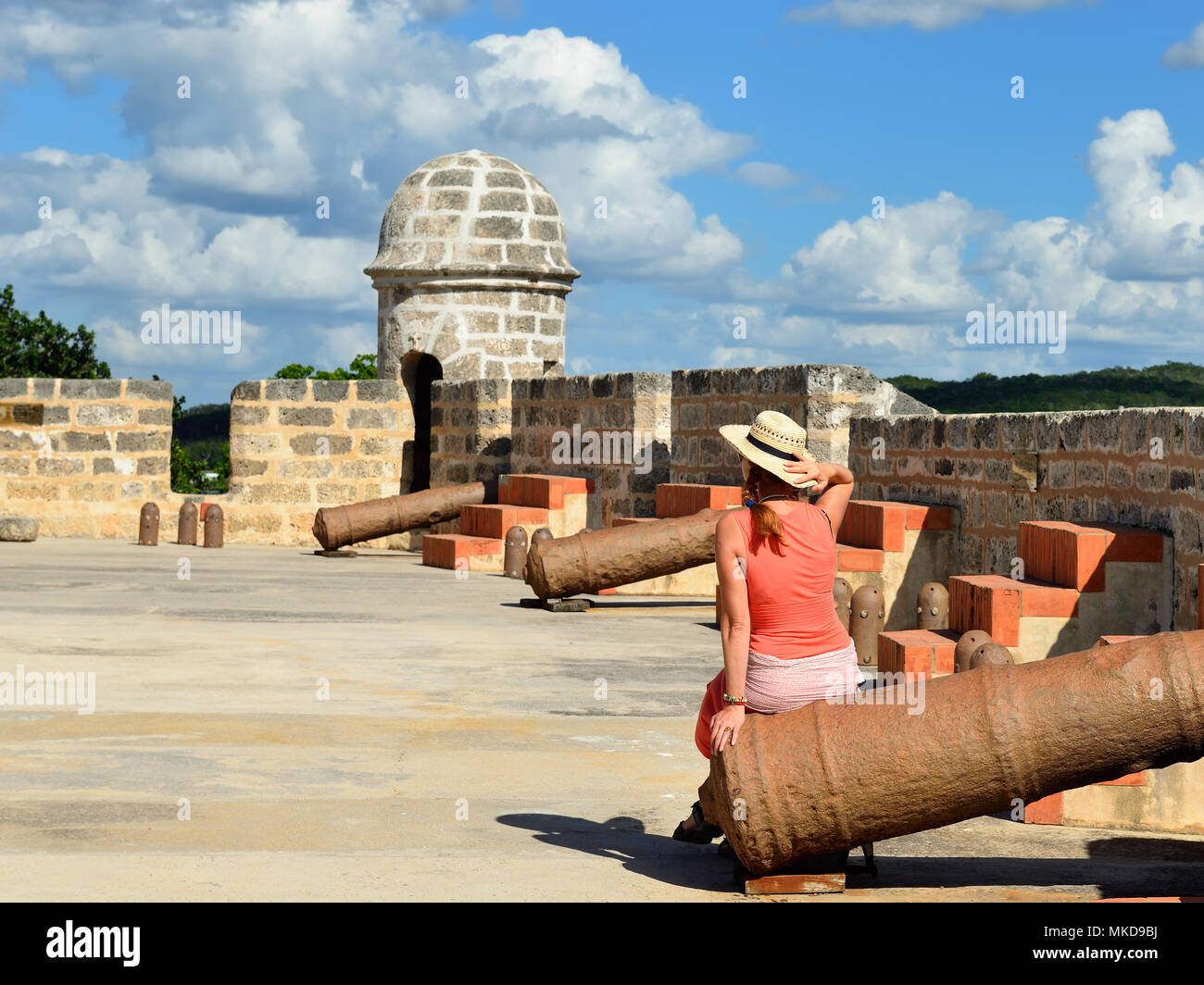The tourist touring the Jagua fort is sitting on the ancient cannon ...